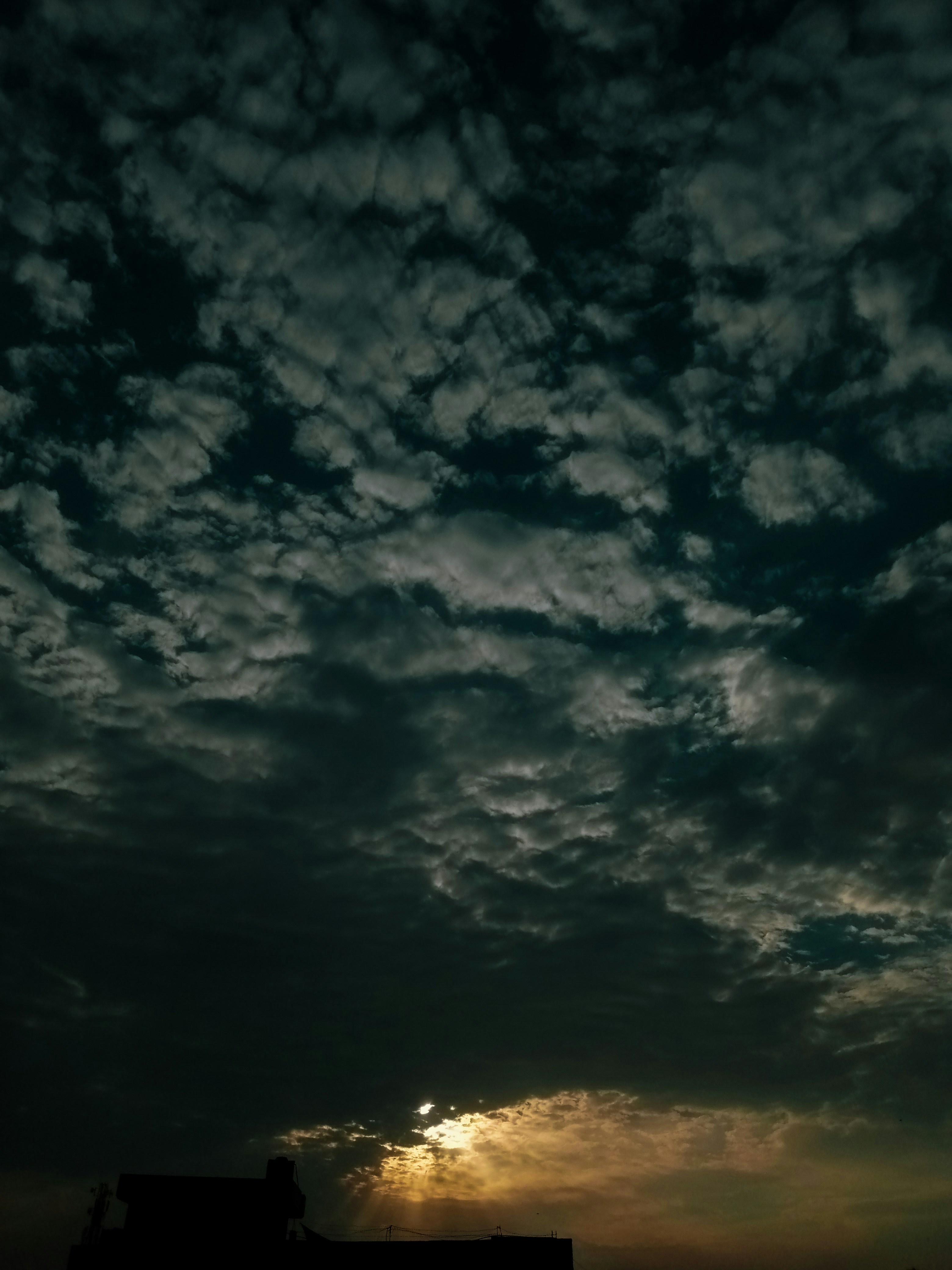 Horizon Fire Through Cloud Veil Behind a Quiet Rooftop Silhouette