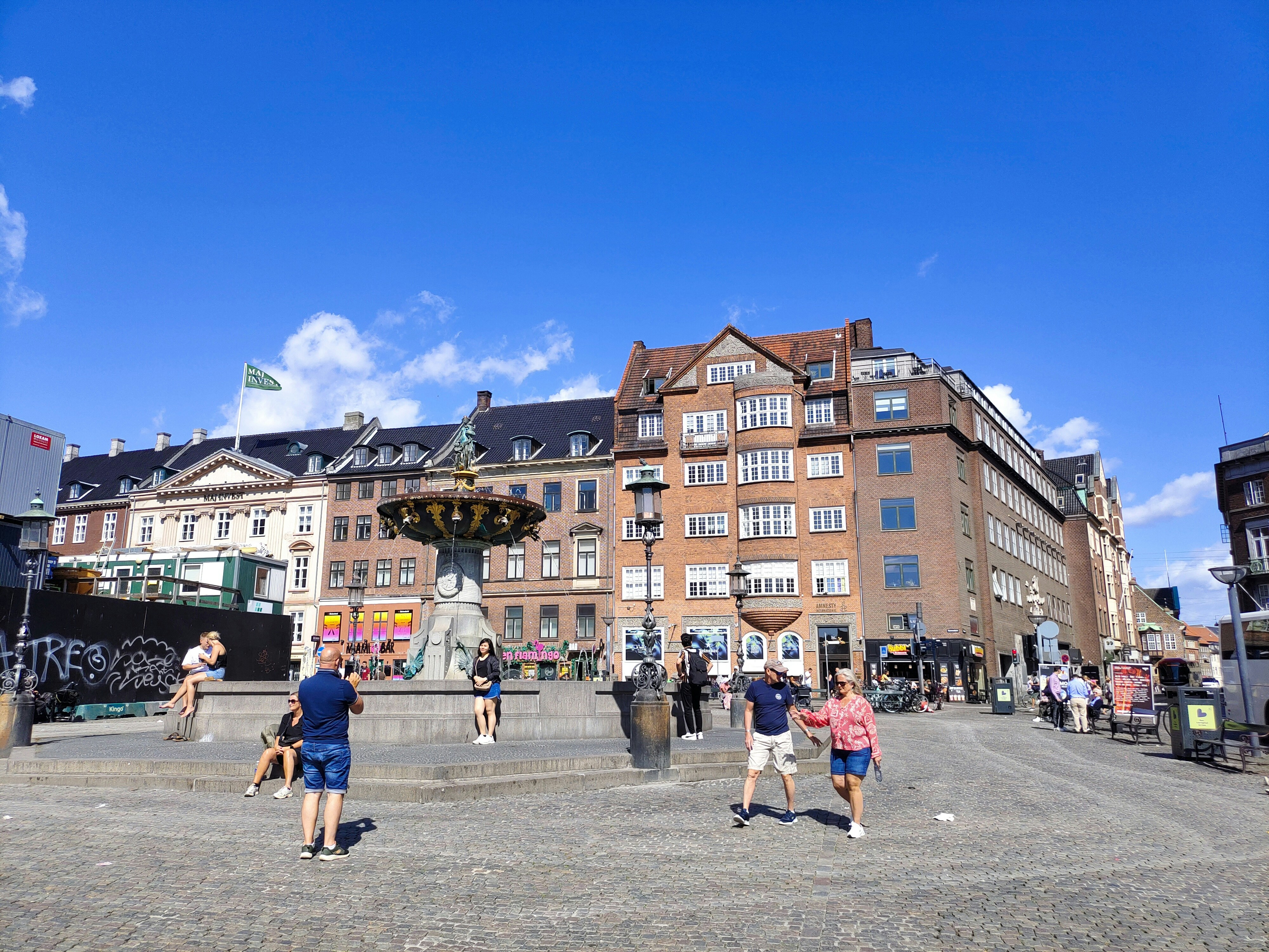 Midday Fountain Pulse in a Brick-Front City Square