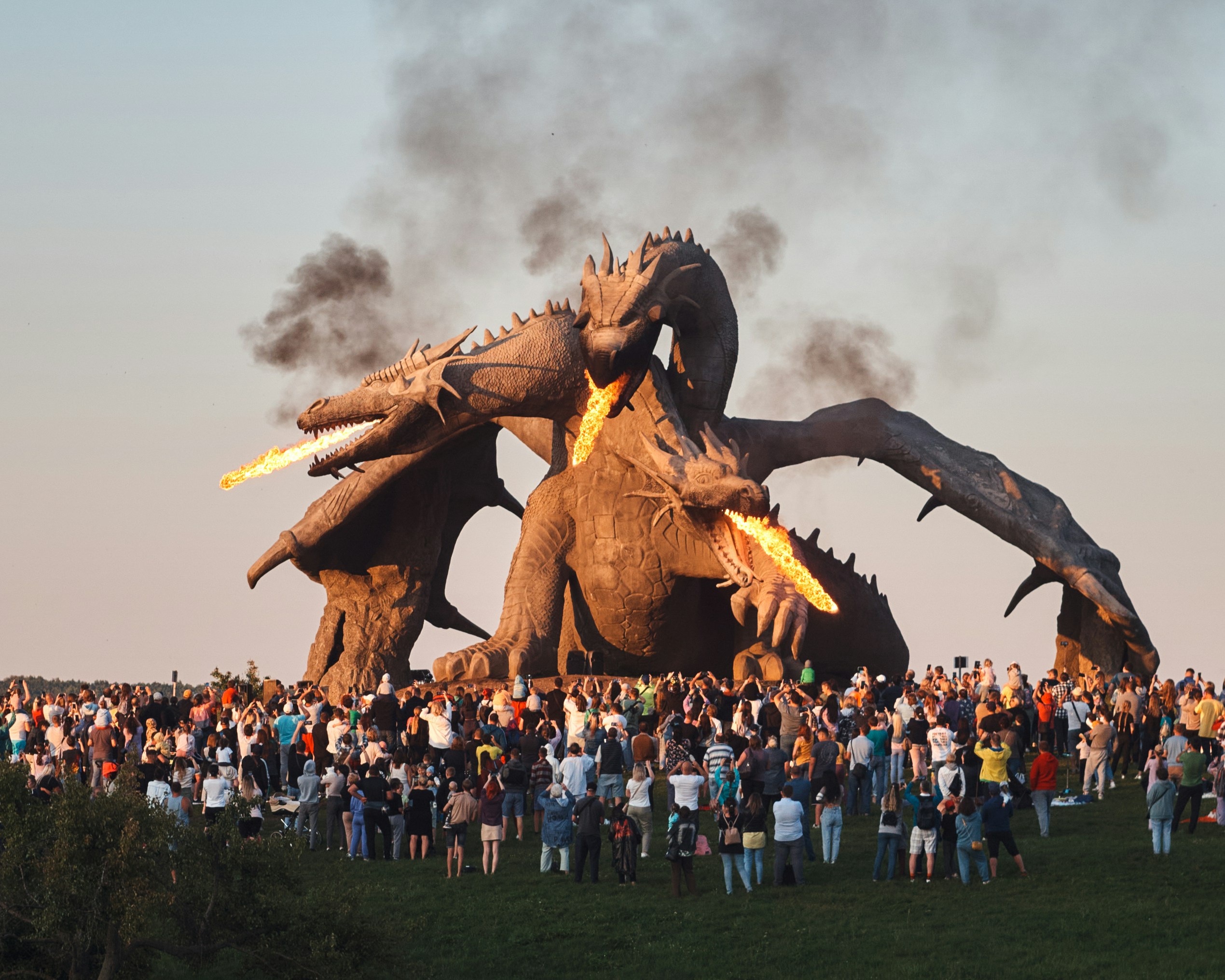 A crowd of people standing around a giant dragon statue photo – Free ...