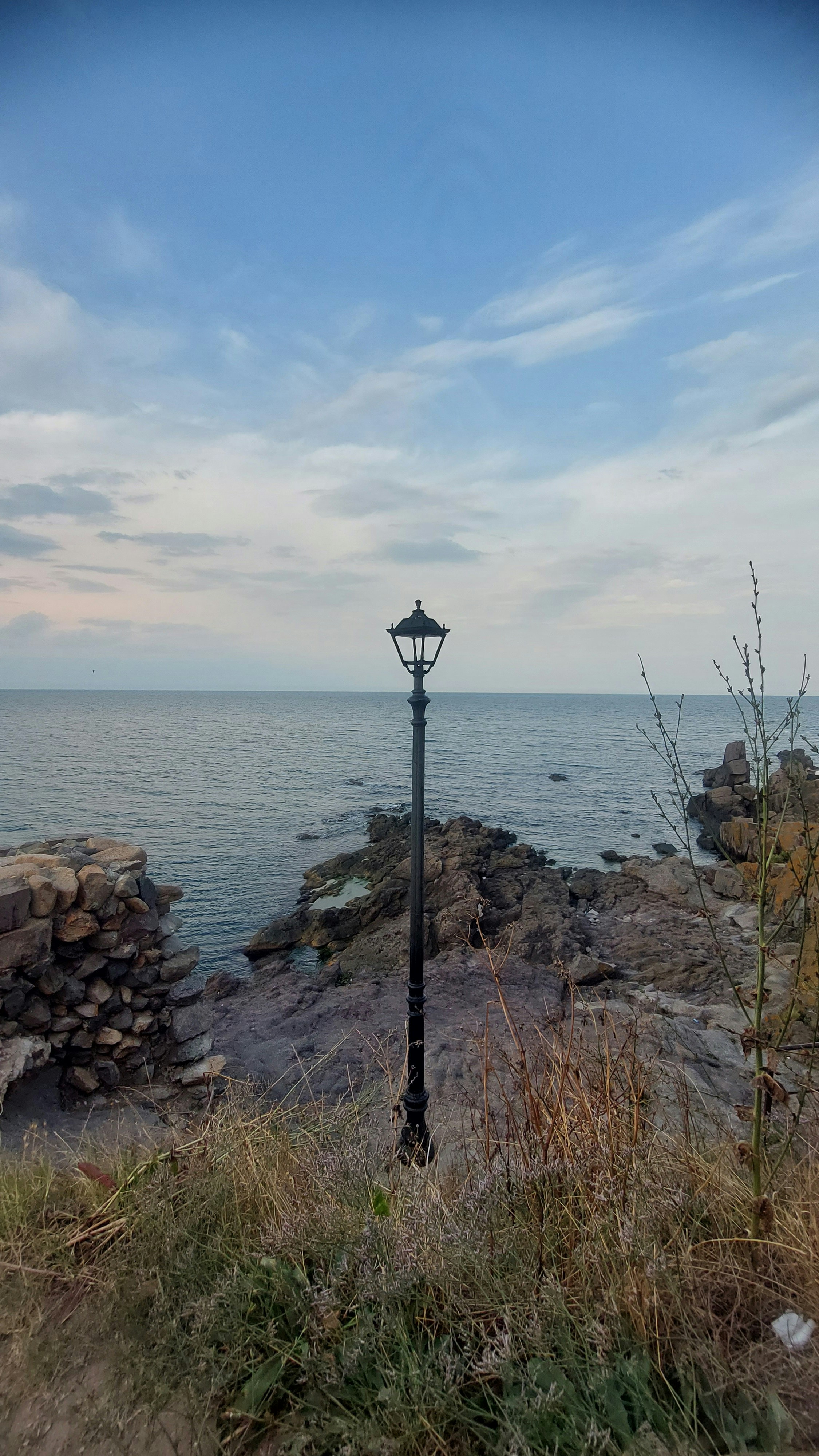 Lone Lantern Standing Guard Over a Rocky Seascape