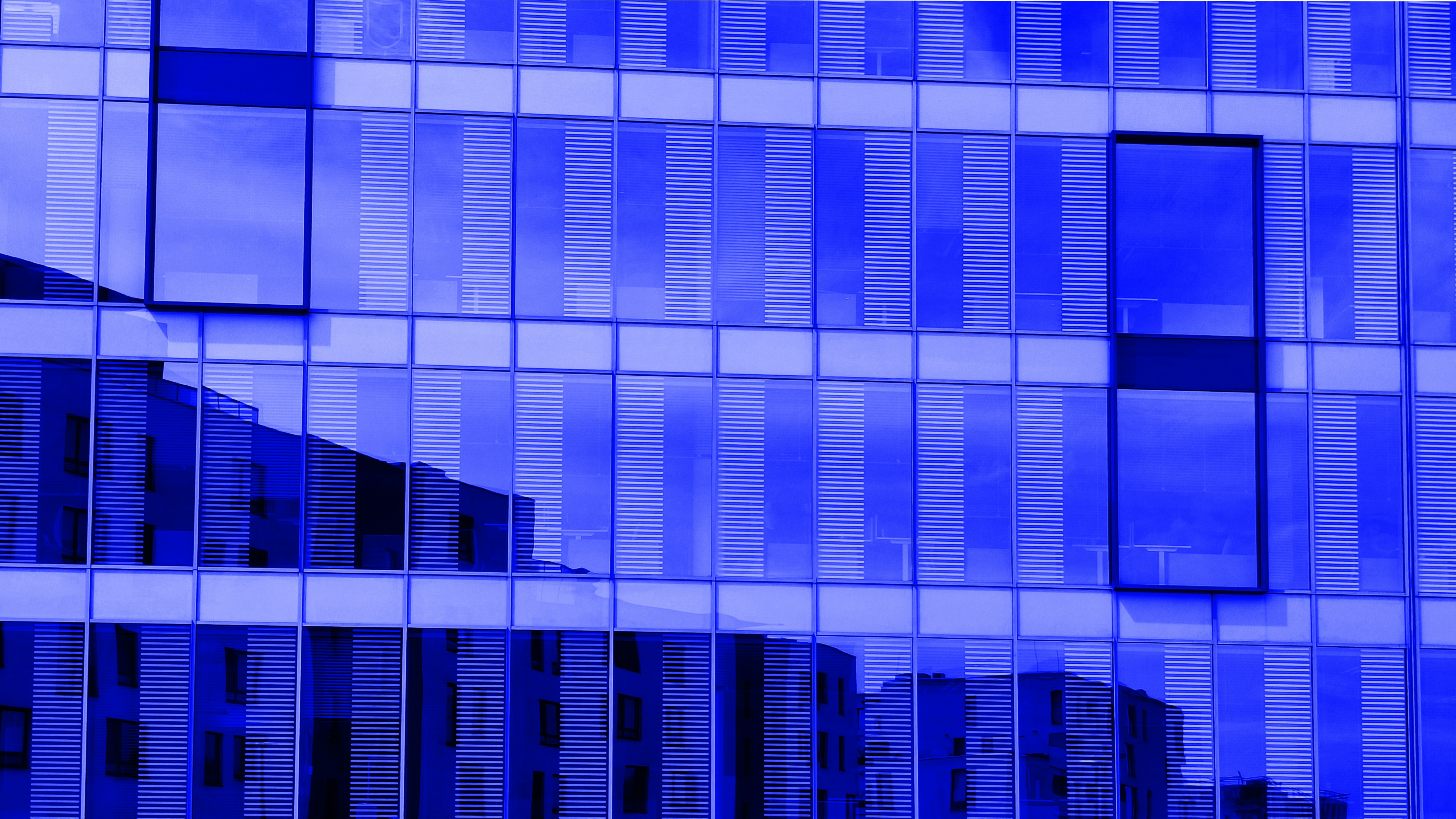 Reflective glass facade with alternating blue and white patterns on a modern office building.
