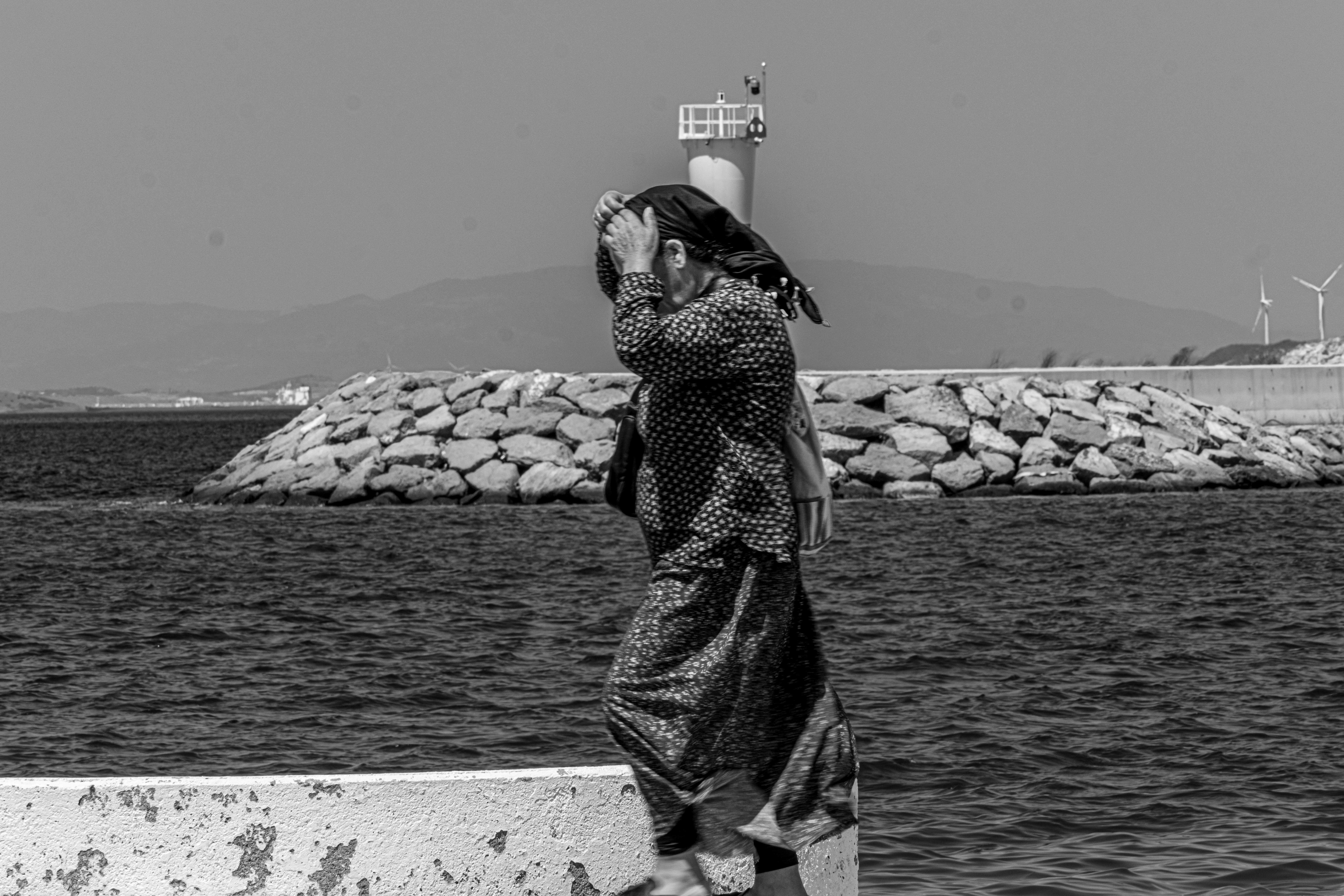 Stride Along the Breakwater: A Quiet Moment by the Lighthouse
