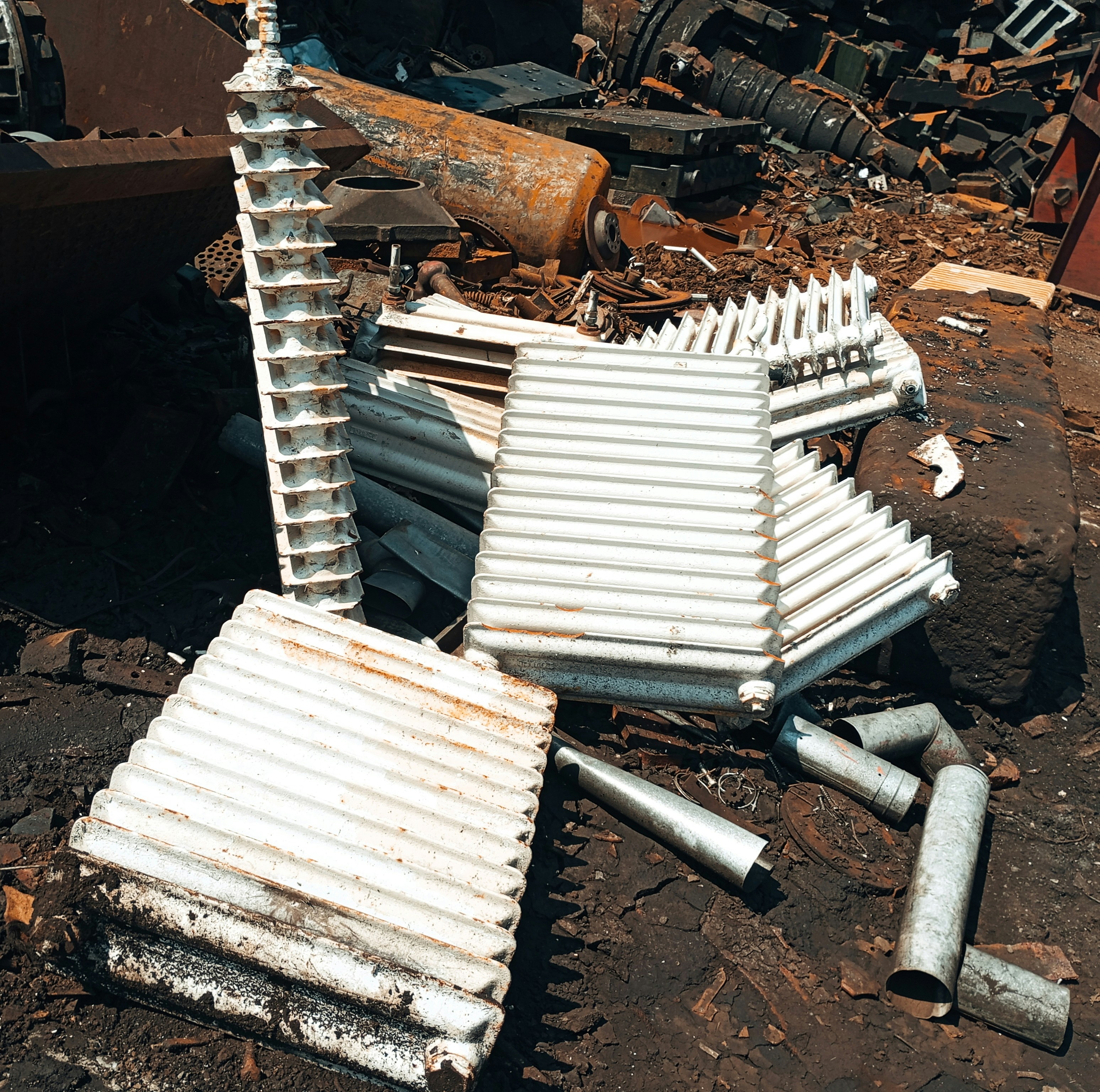 Geometric White Panels Among Rust: A Scrapyard's Quiet Chaos