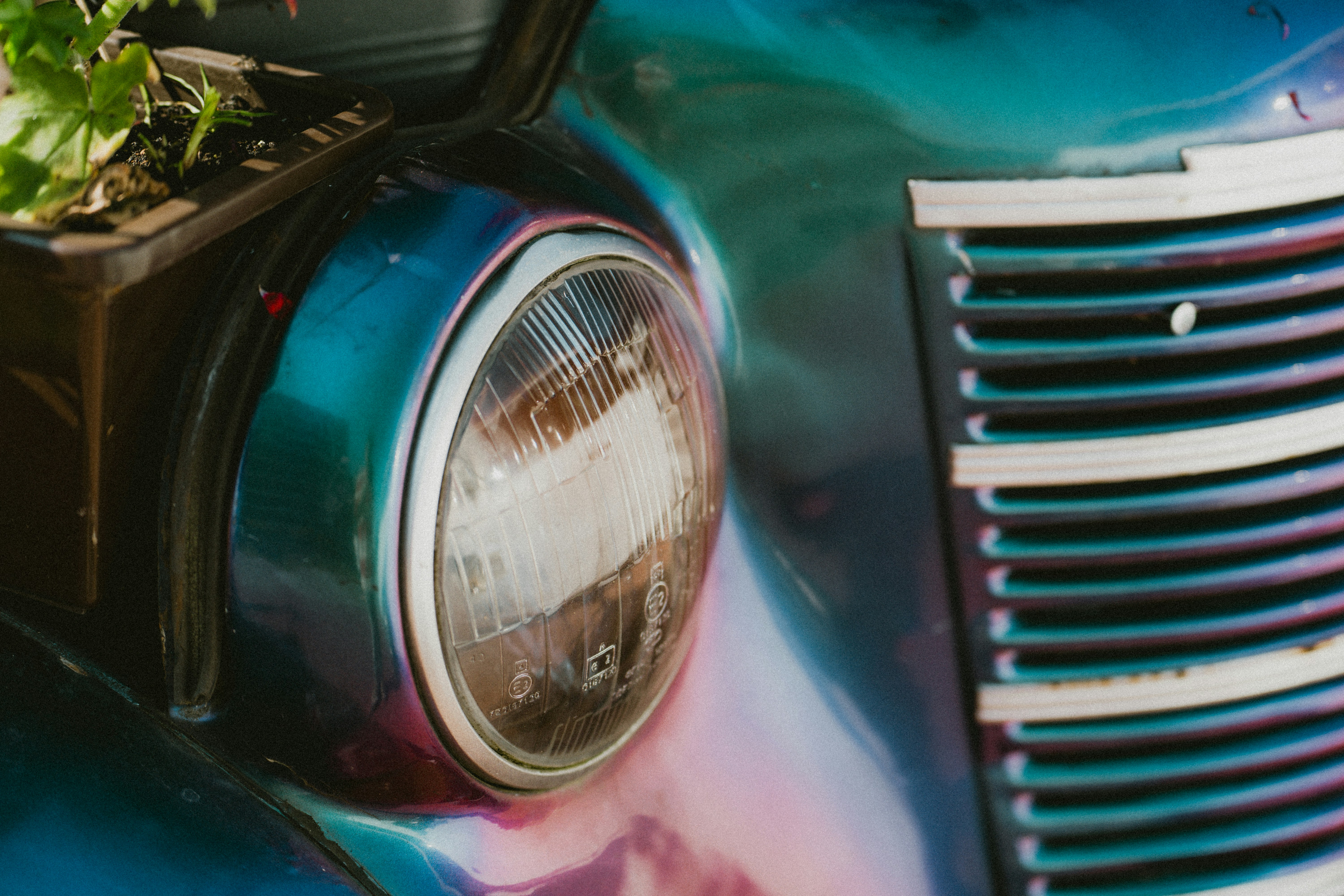 Neon Patina: Close-Up of a Vintage Car Headlight Amid Colorful Chrome