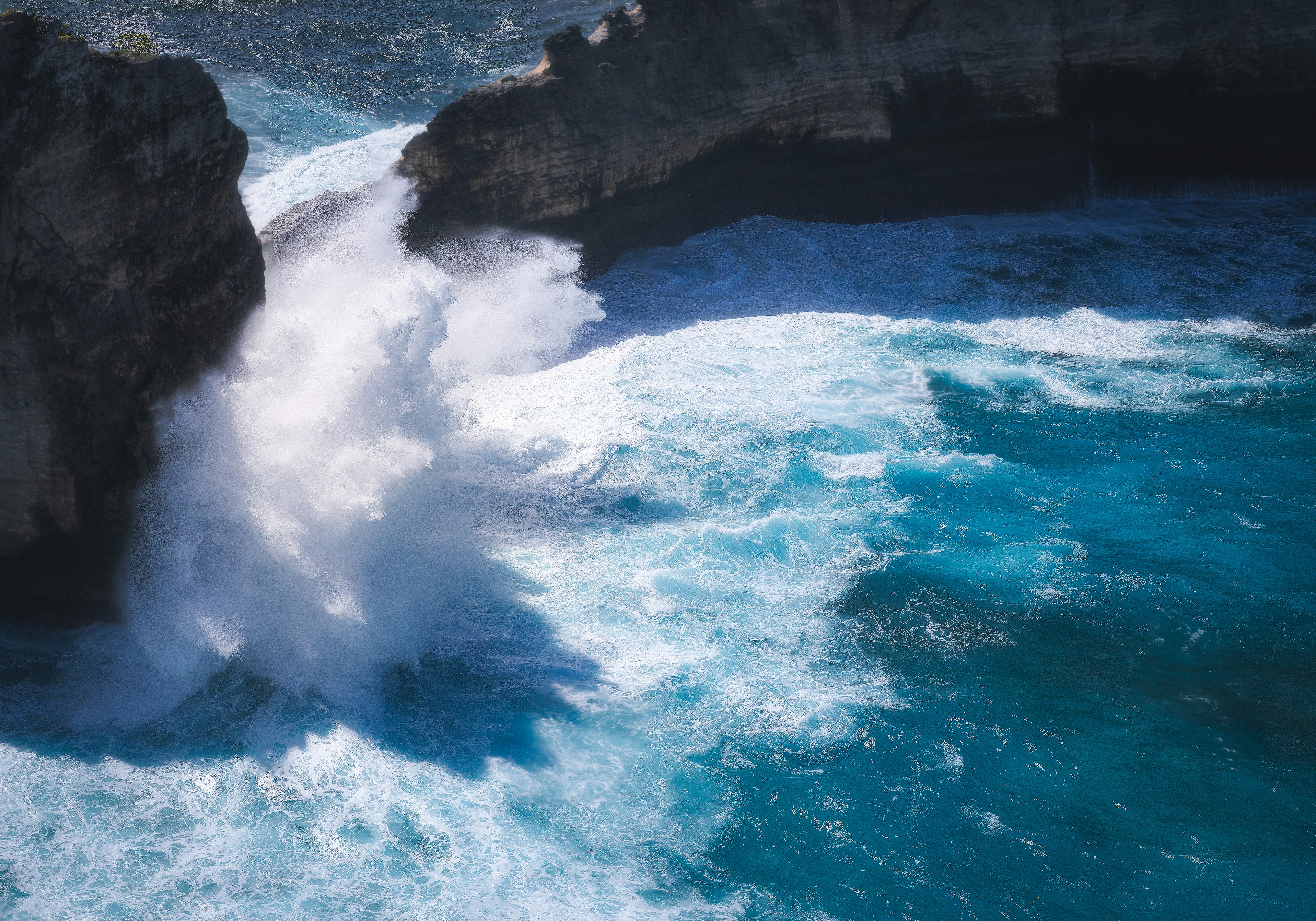 A large wave crashes into the rocks near the ocean photo – Free Bali ...