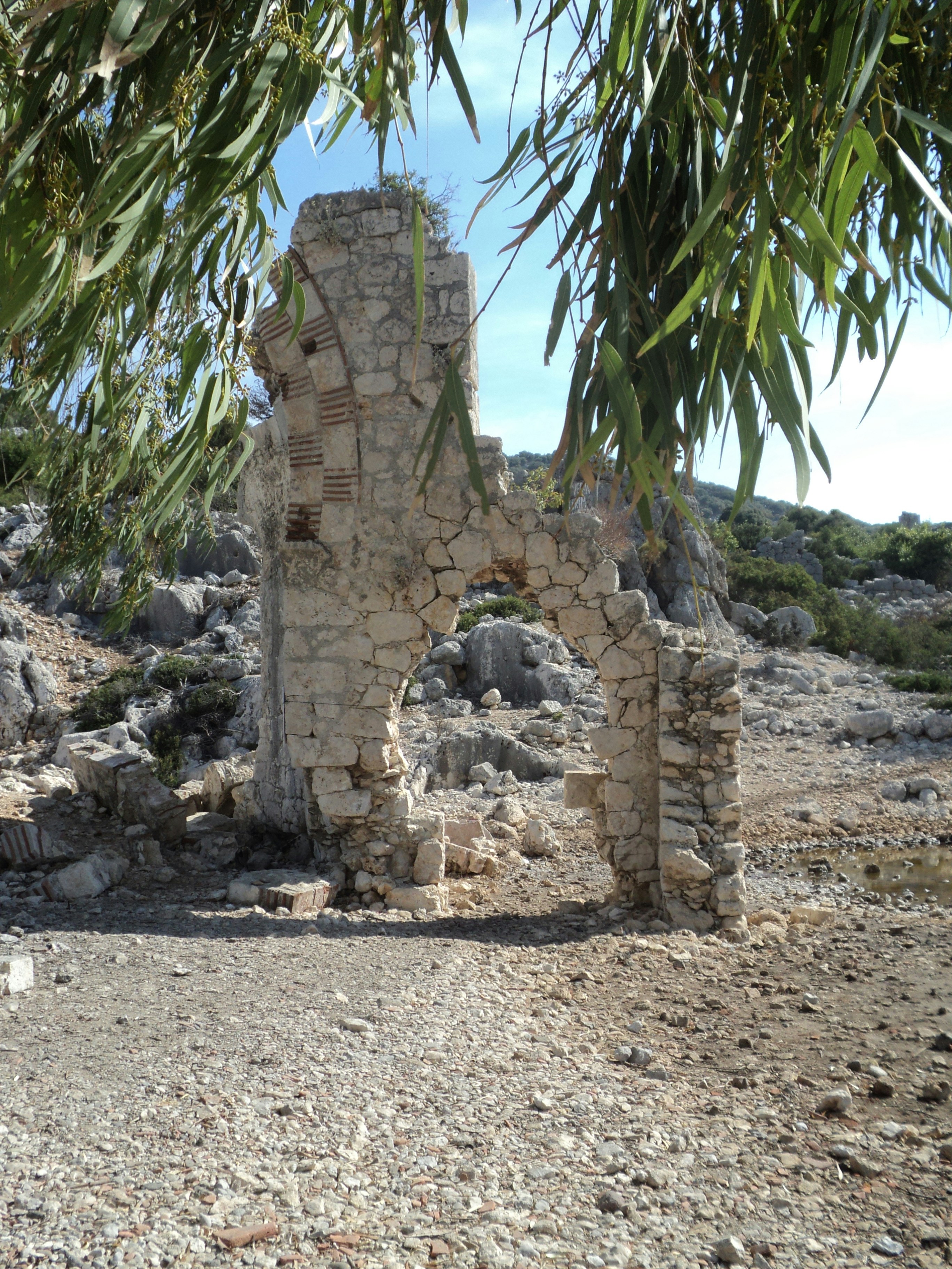 a stone structure sitting on top of a dirt field