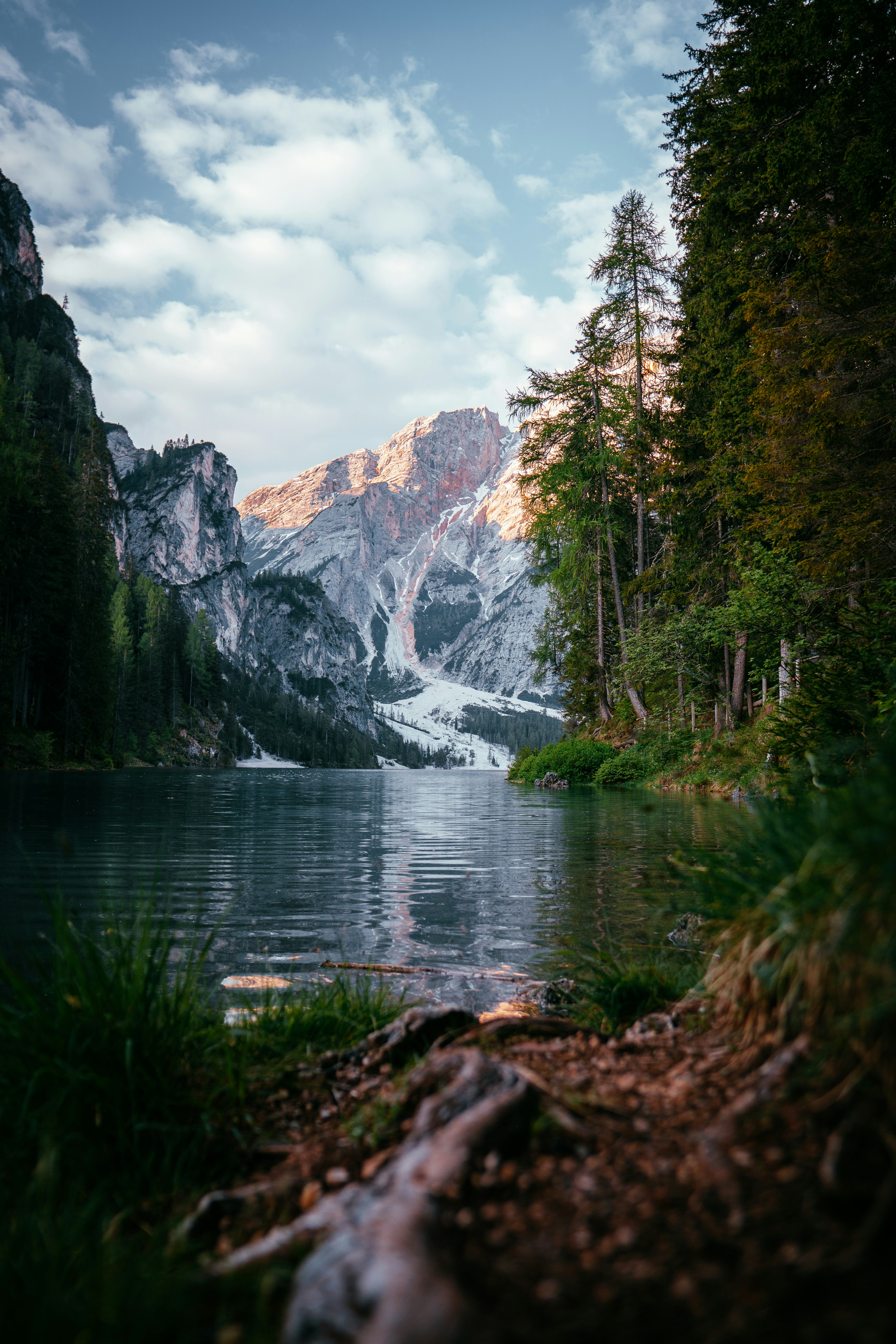 A body of water surrounded by trees and mountains photo – Free Pragser ...