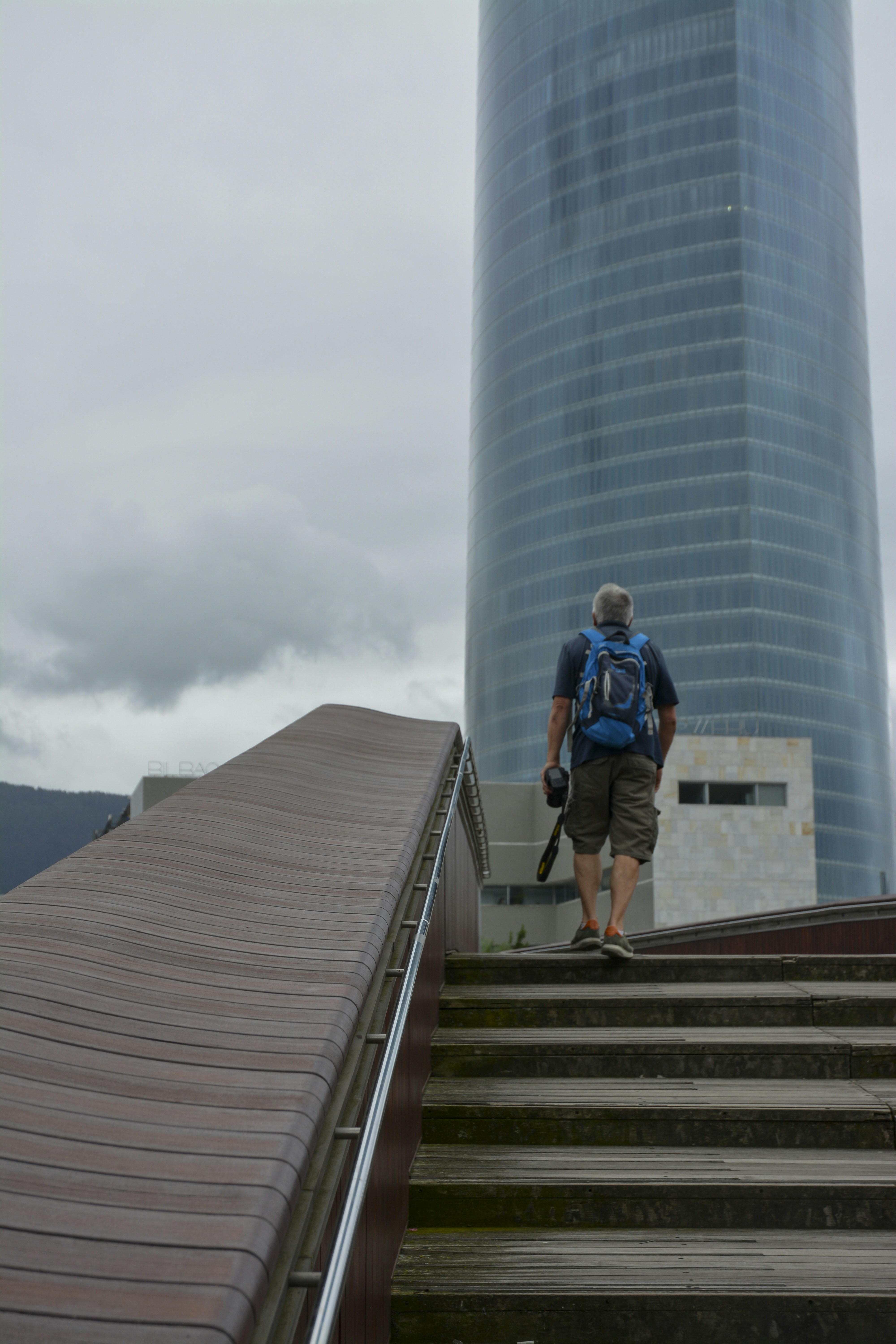 a man with a backpack walking up a flight of stairs