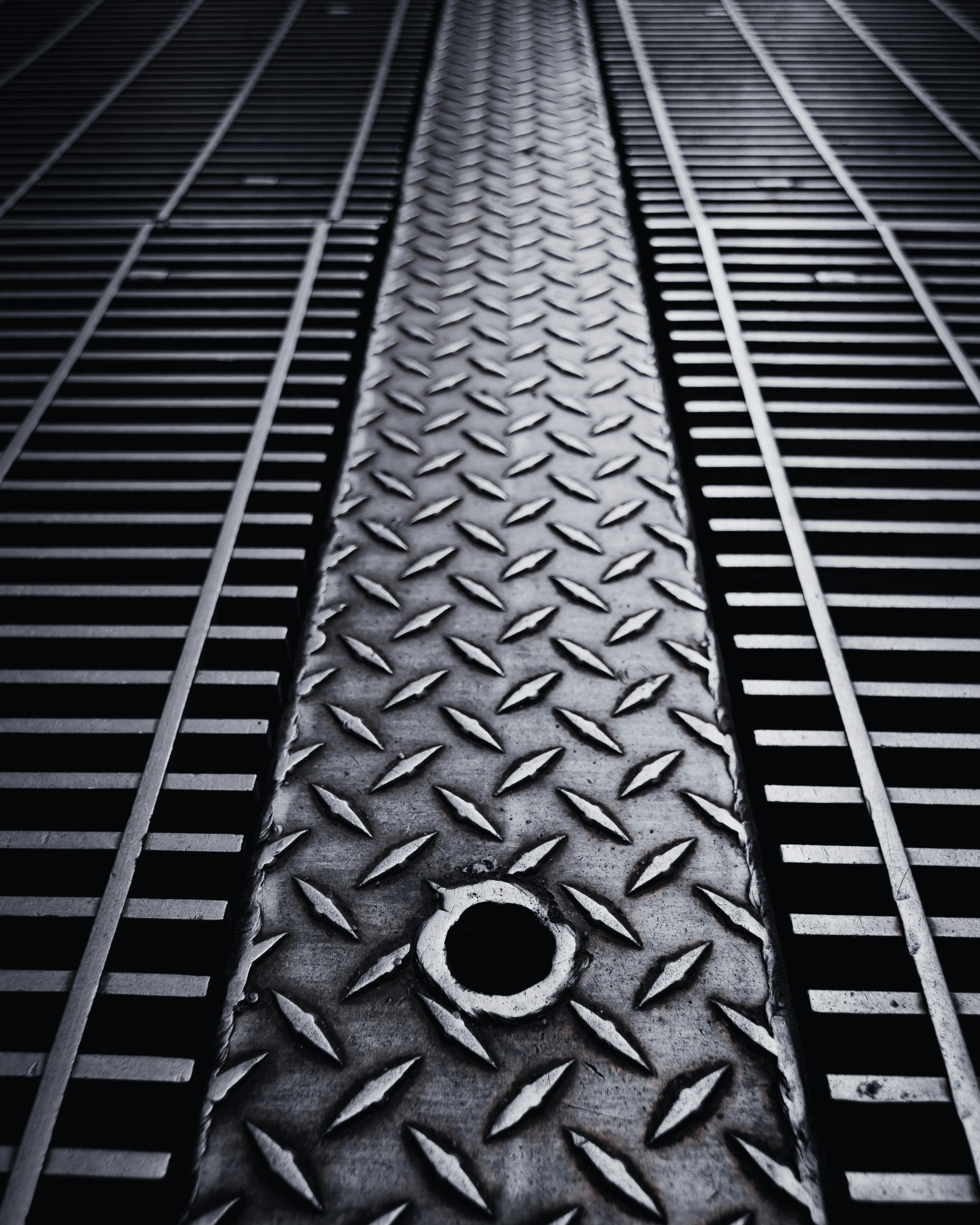 Diamond-Plate Axis: A Monochrome Walkway Between Grates