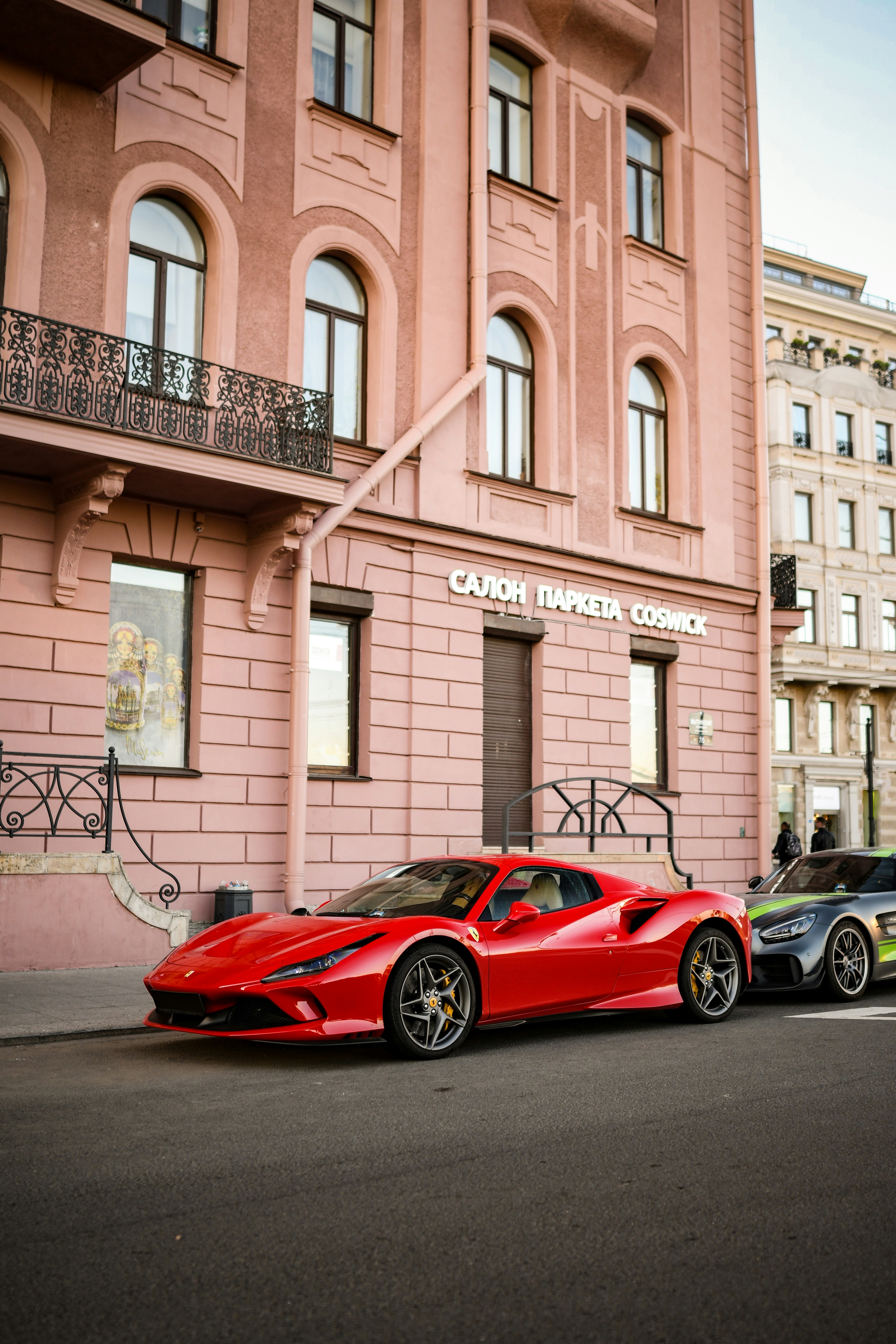 Crimson Ferrari Posed Before a Pastel Pink Facade