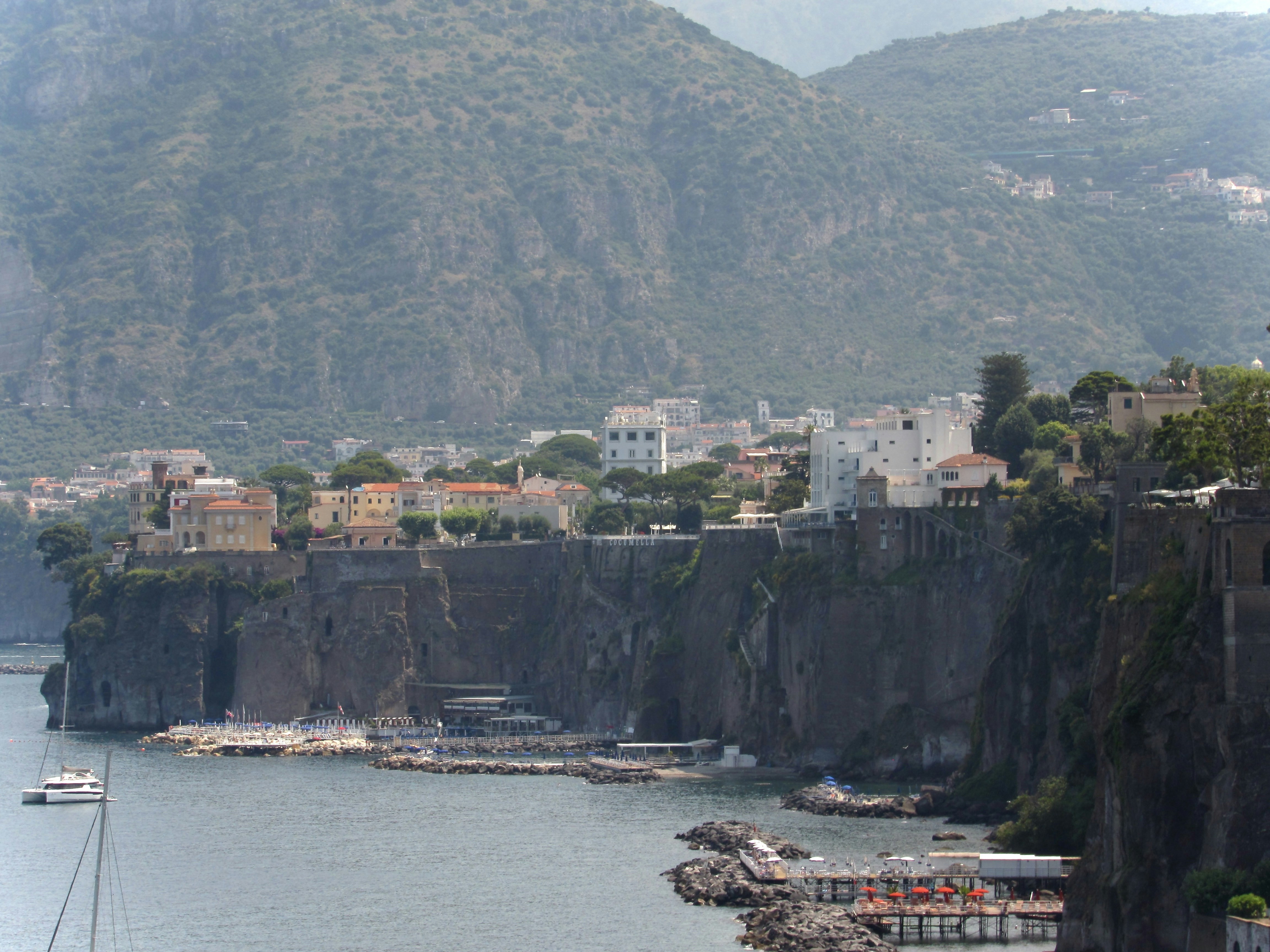A city on a cliff overlooking a body of water photo – Free Cliff Image ...
