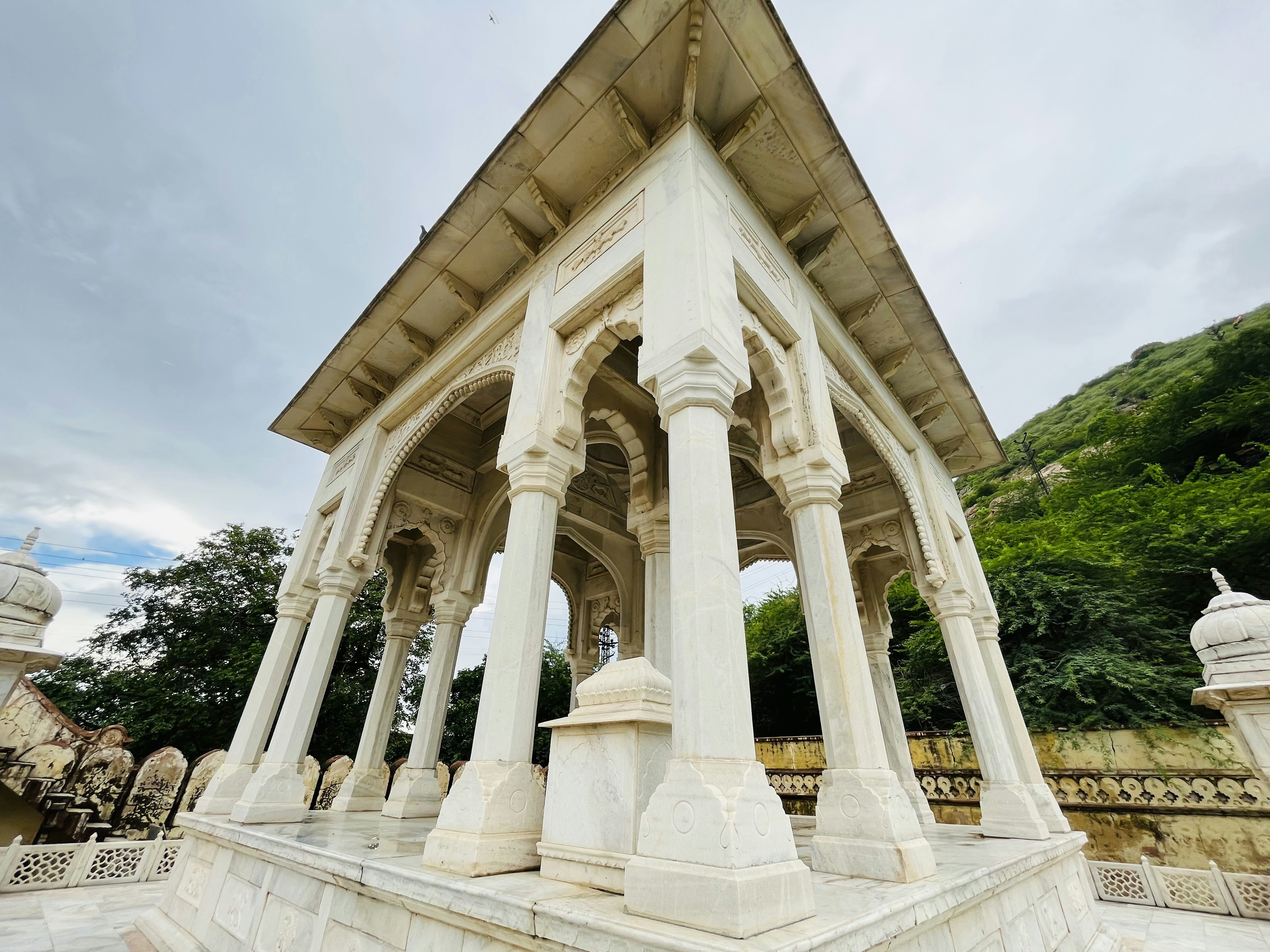 A white building with pillars and a clock tower in the background photo ...