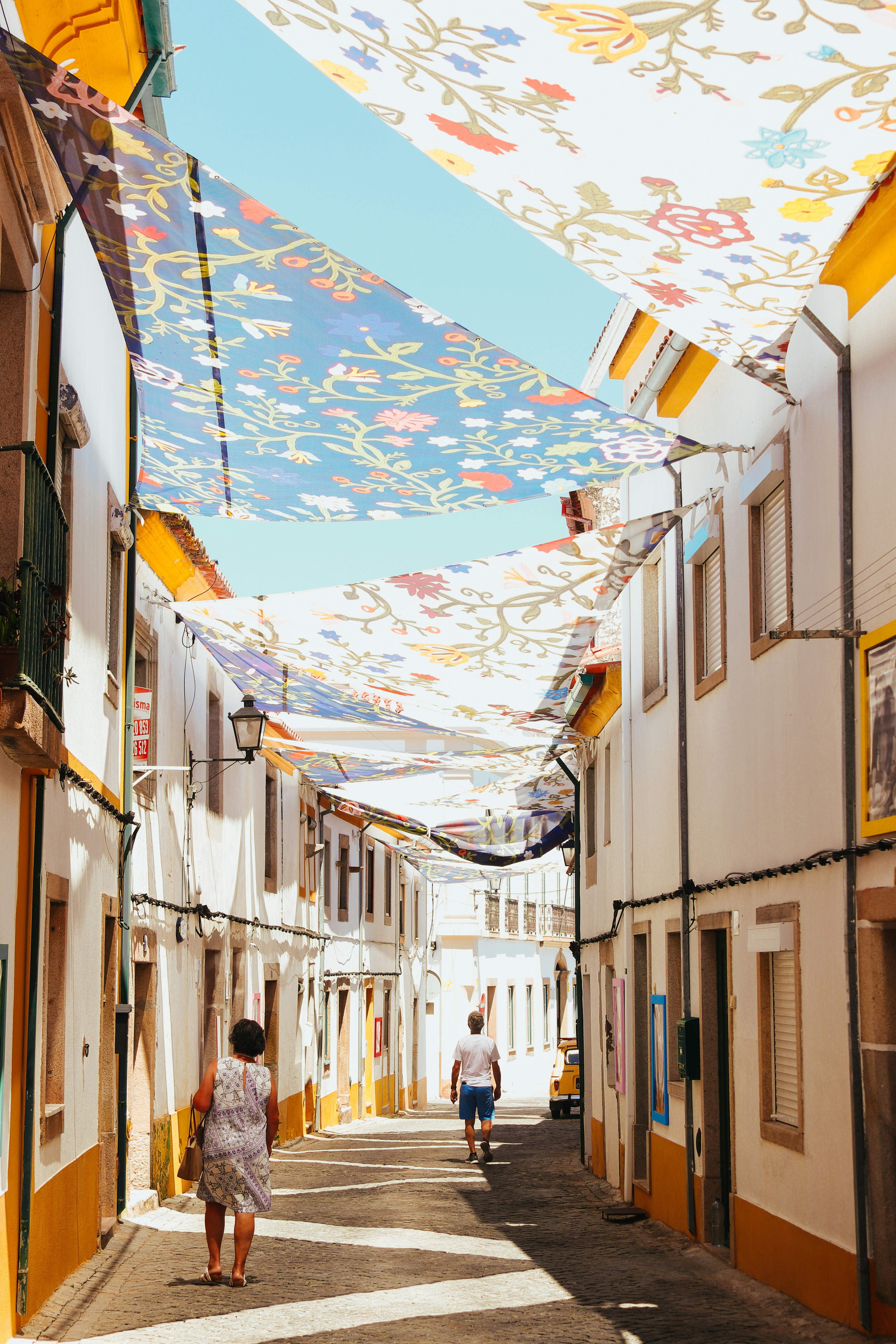 Sunlit Alley Under a Floral Canopy: A Patchwork of Sails