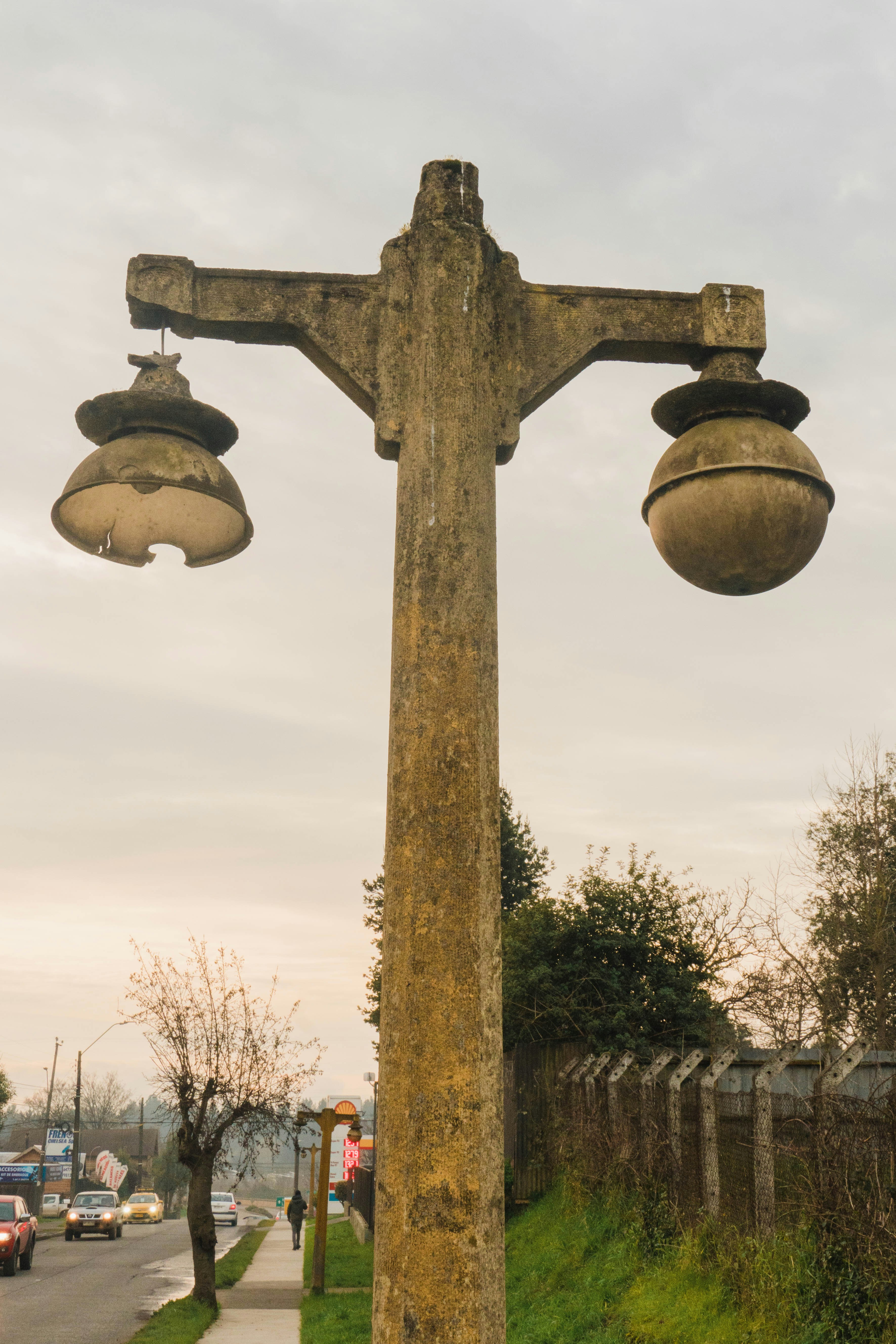 The Weathered Cross: Vintage Street Lamps Framing a Quiet Road