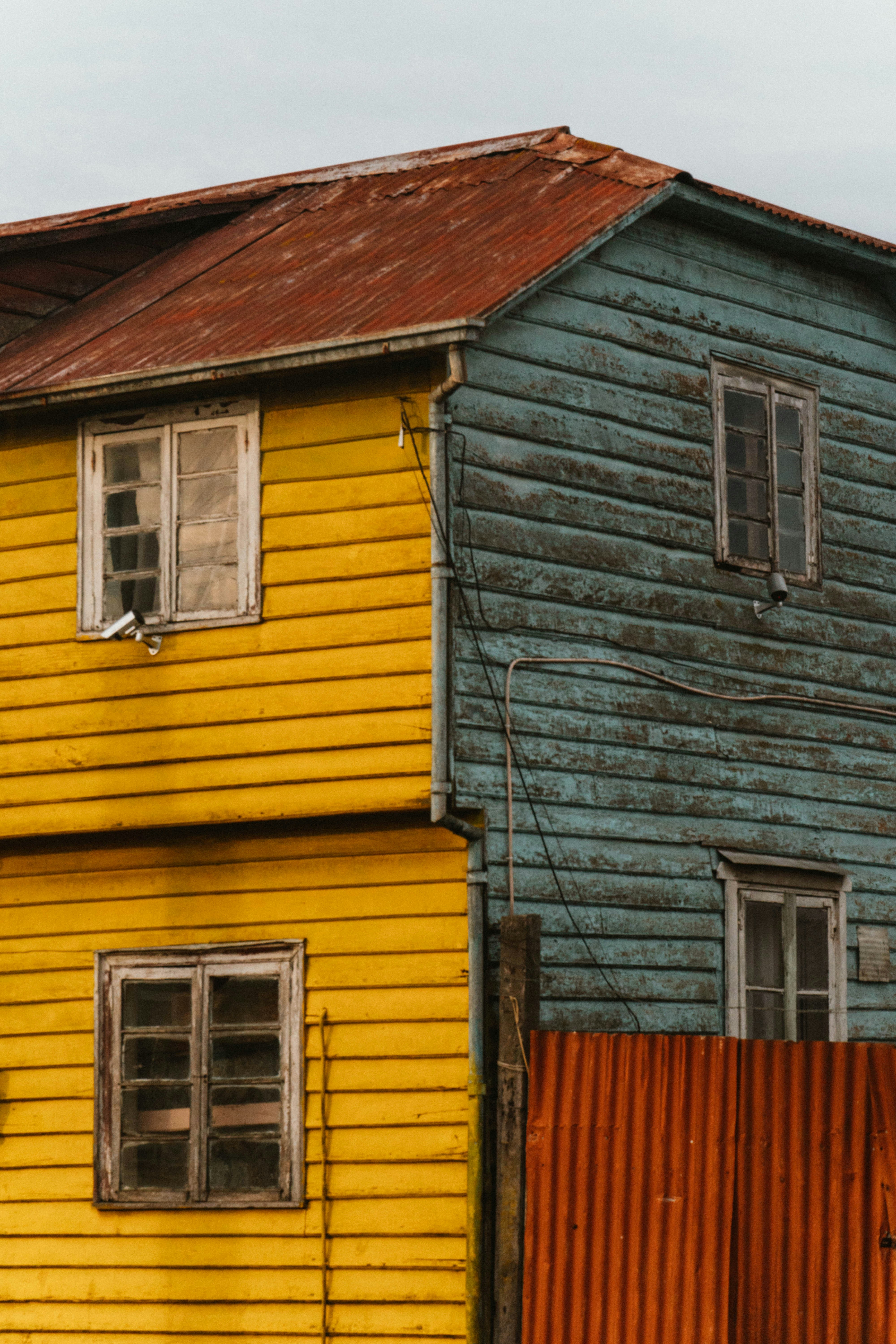 Color-Blocked Corner: A Weathered Two-Tone House with a Rusted Roof
