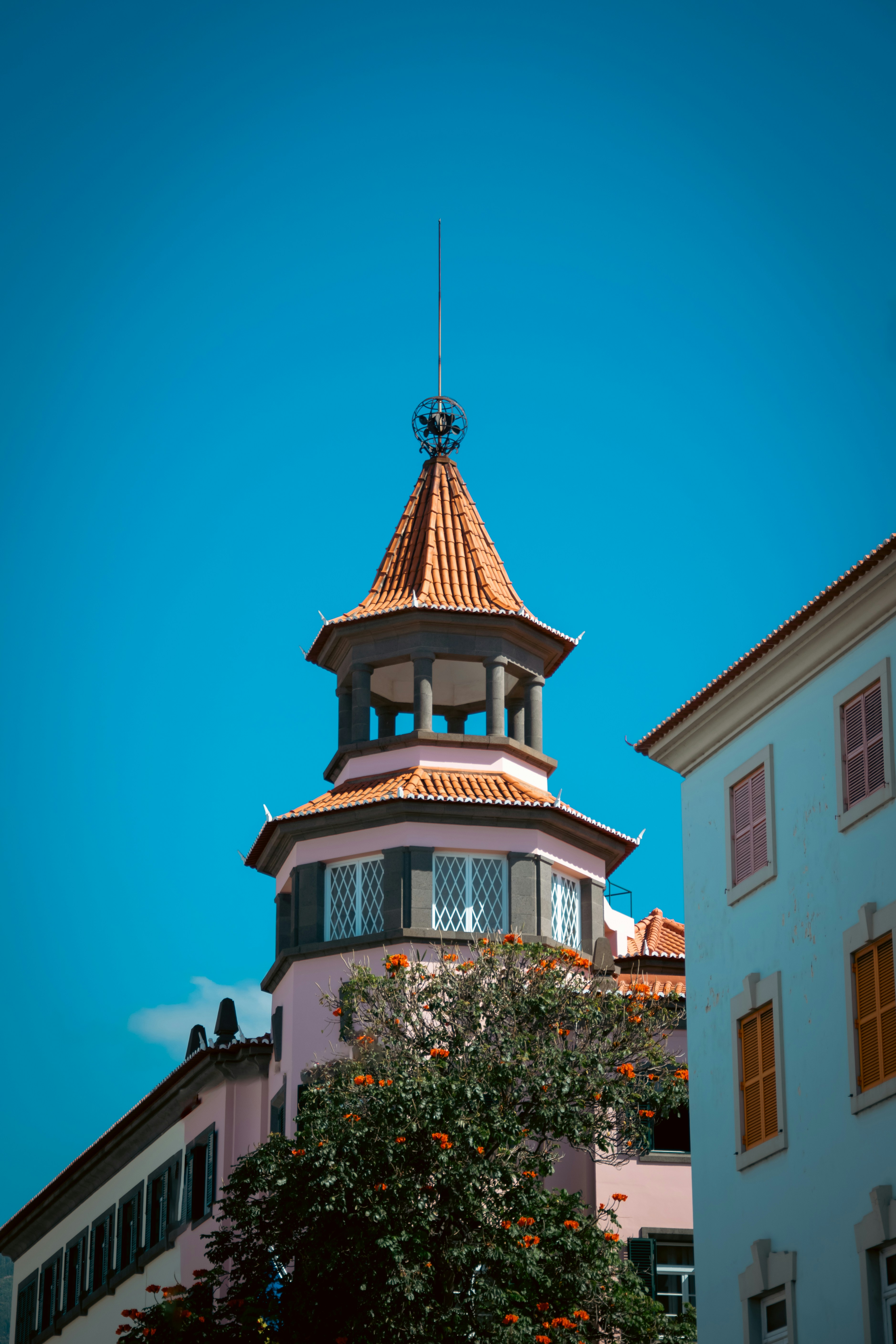Terracotta-Topped Clock Tower Reaches Toward a Crystal Blue Sky