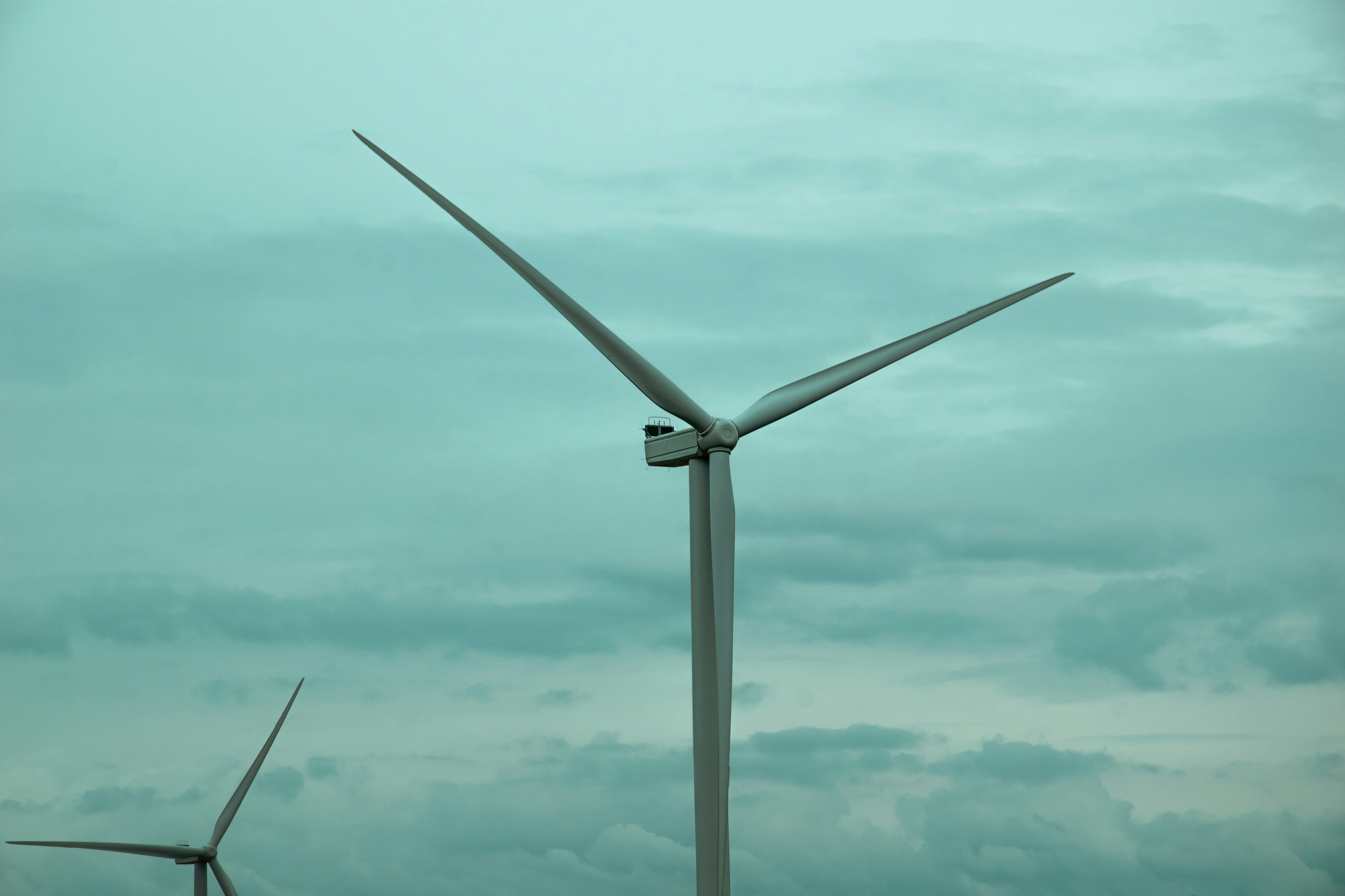 Foto Un parque eólico con dos molinos de viento al fondo – Imagen ...