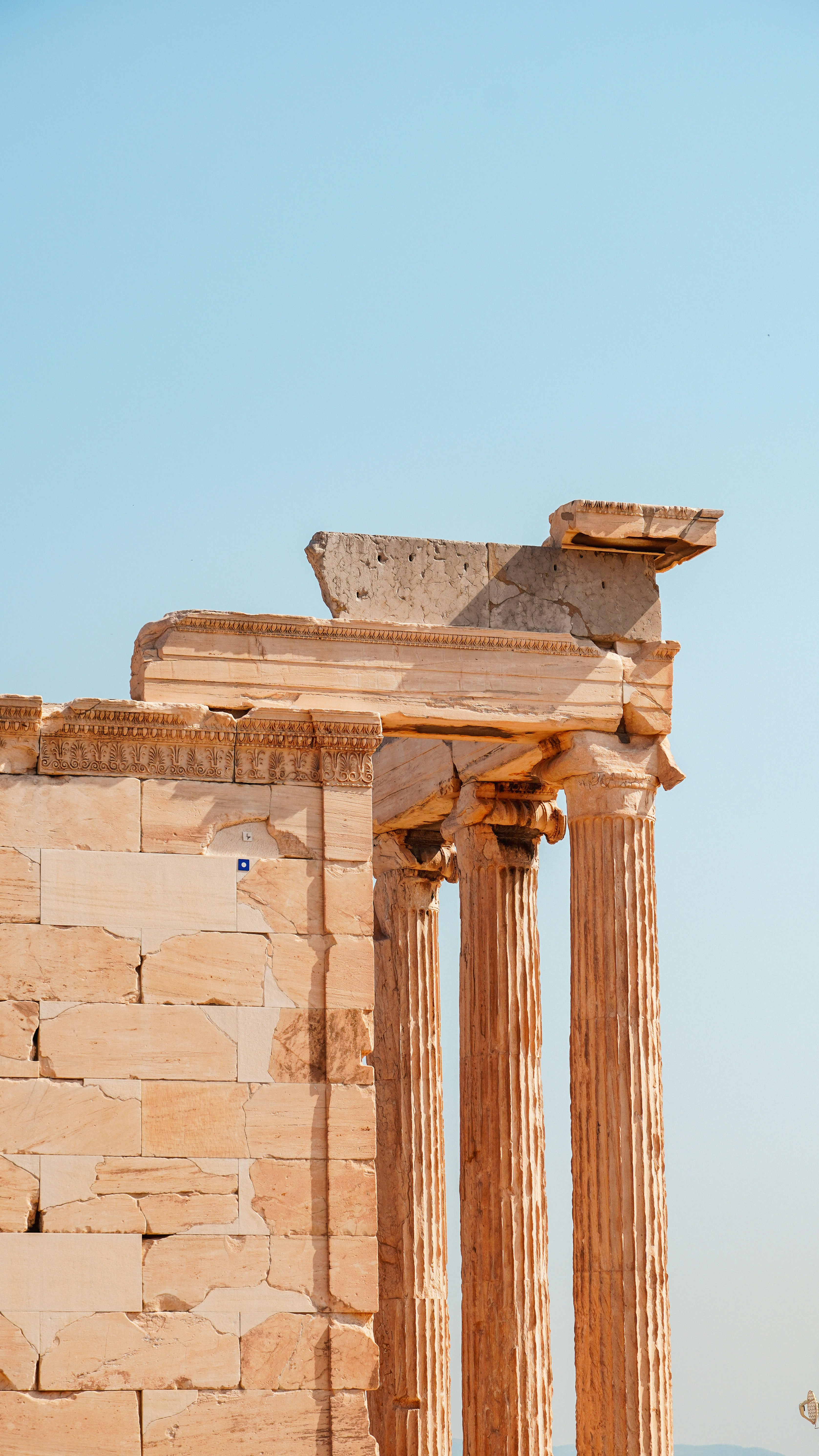 A tall stone building with two large pillars photo – Free Grecia Image ...