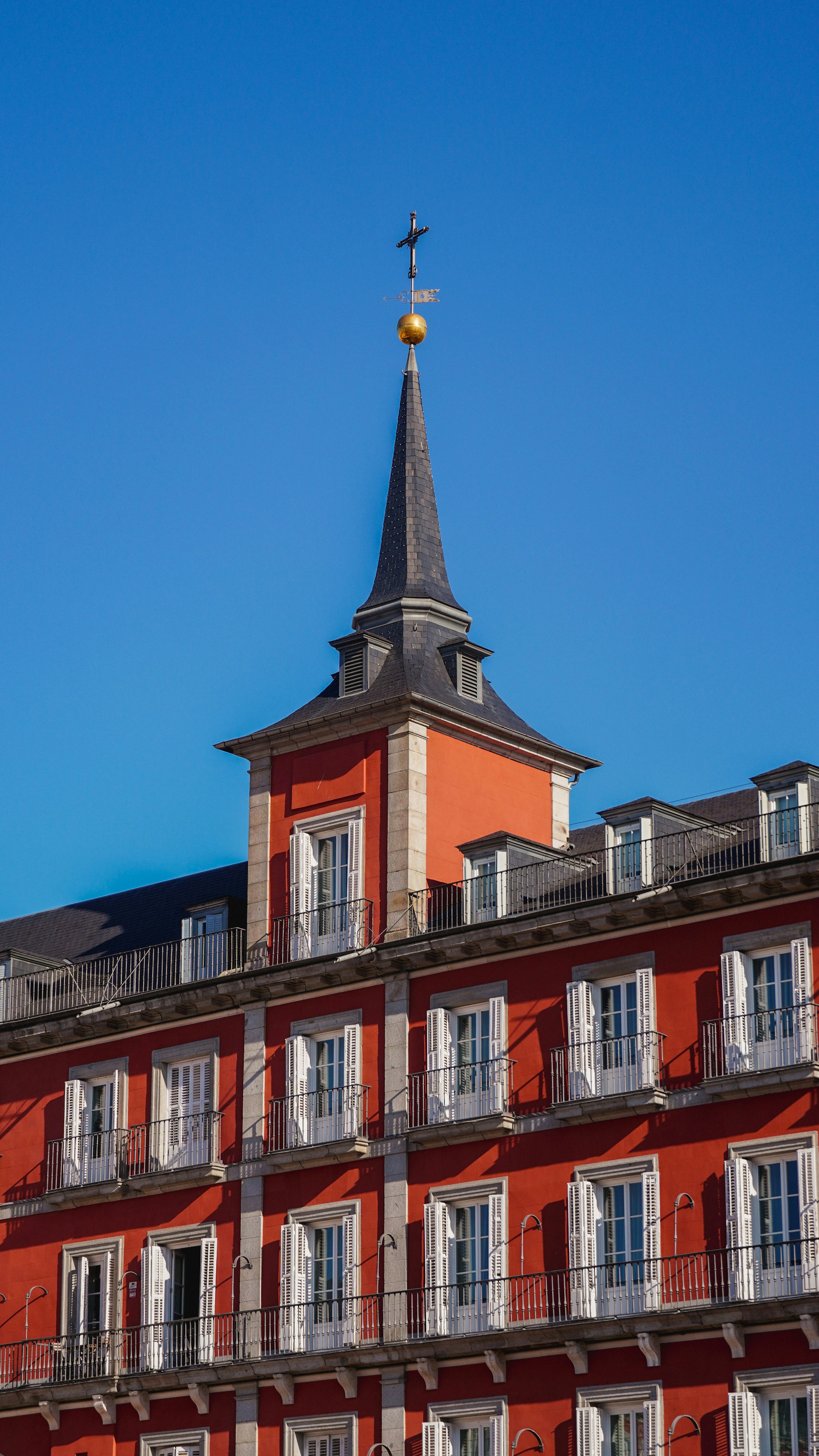 A tall red building with a cross on top photo – Free Madrid Image on ...