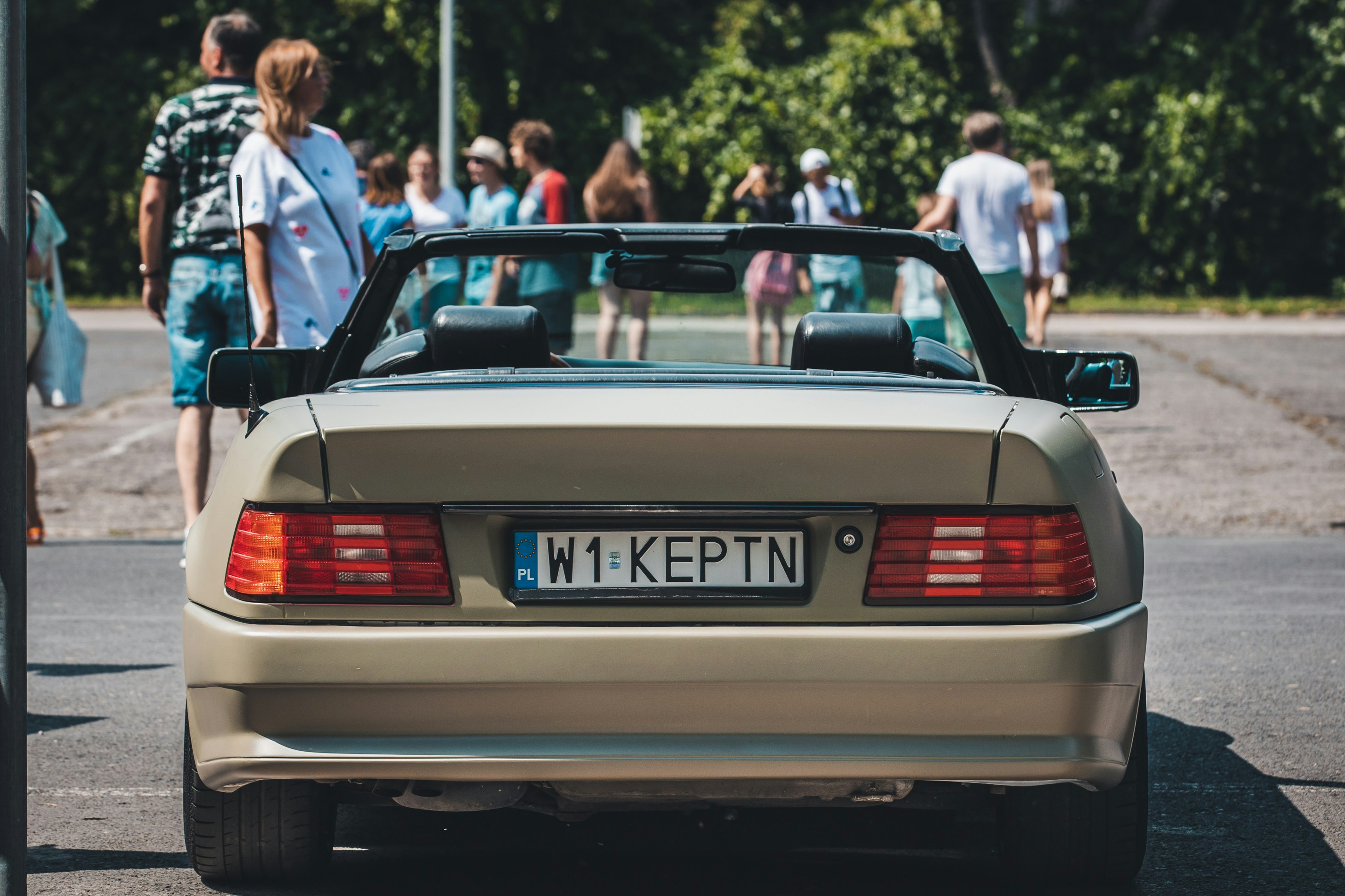 Beige Convertible Backstage: Parking Lot Portrait Amidst a Crowd