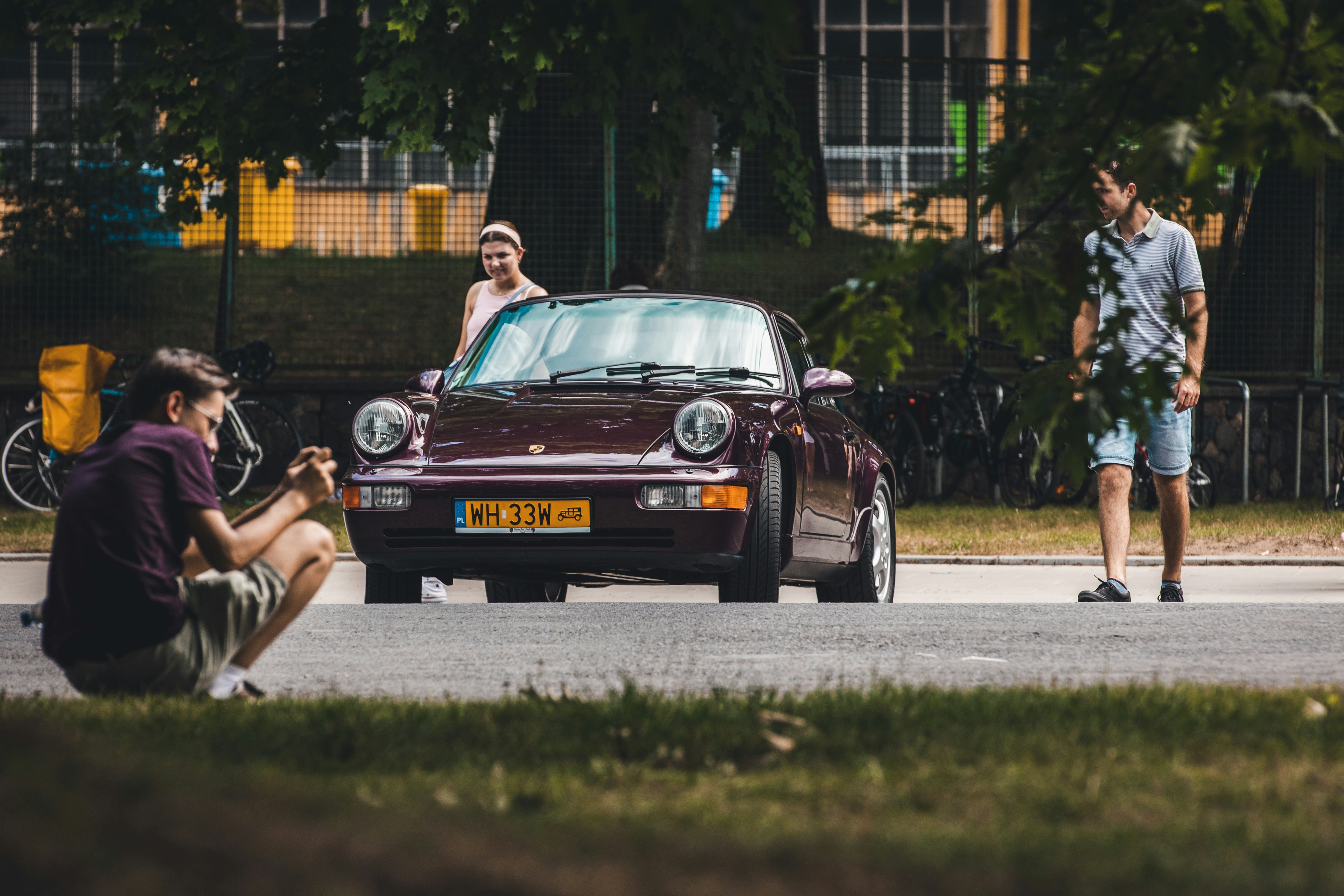 Burgundy 911 on a Quiet City Street: A Casual Shoot with Onlookers
