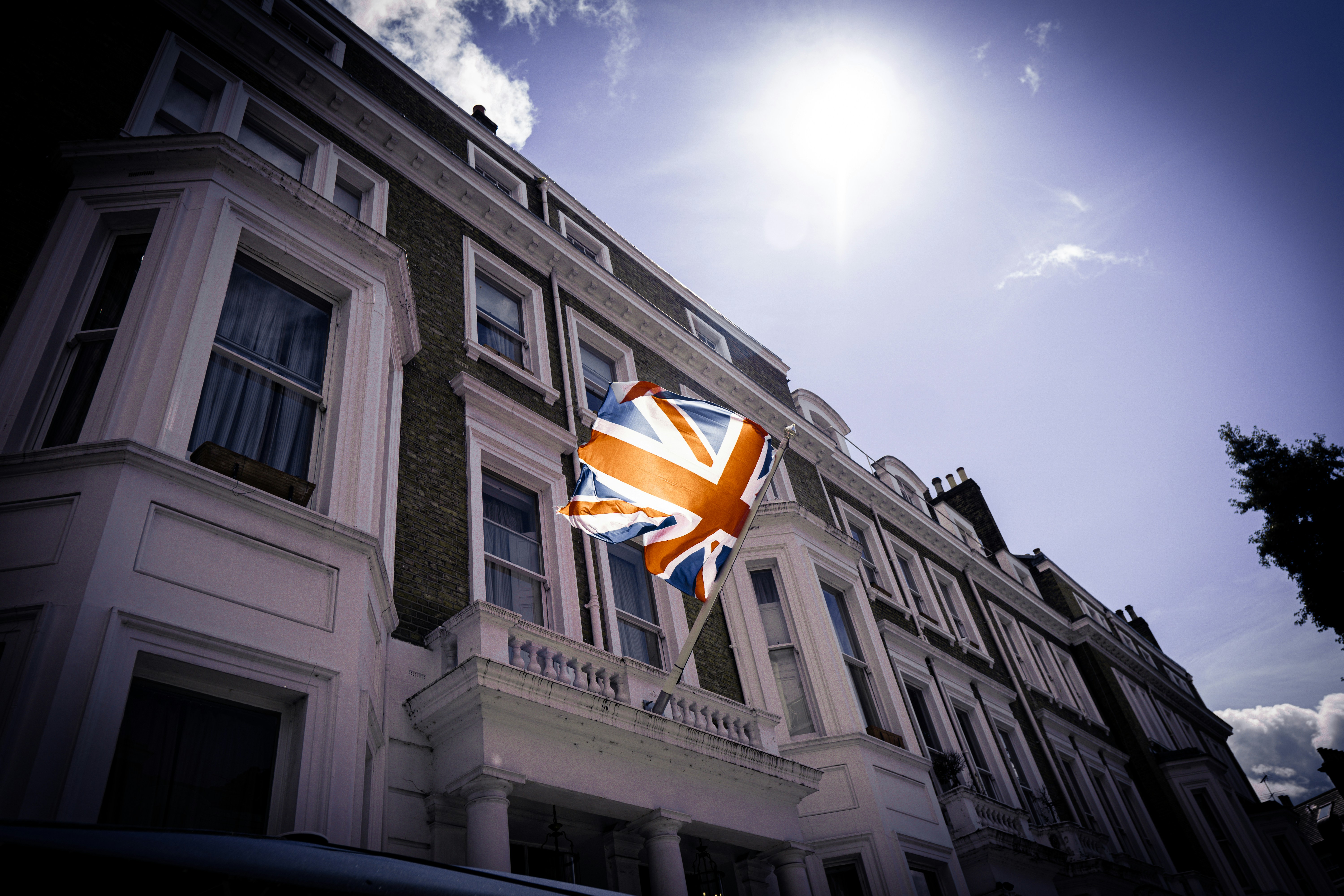 A flag flying in the wind in front of a building photo – Free London ...
