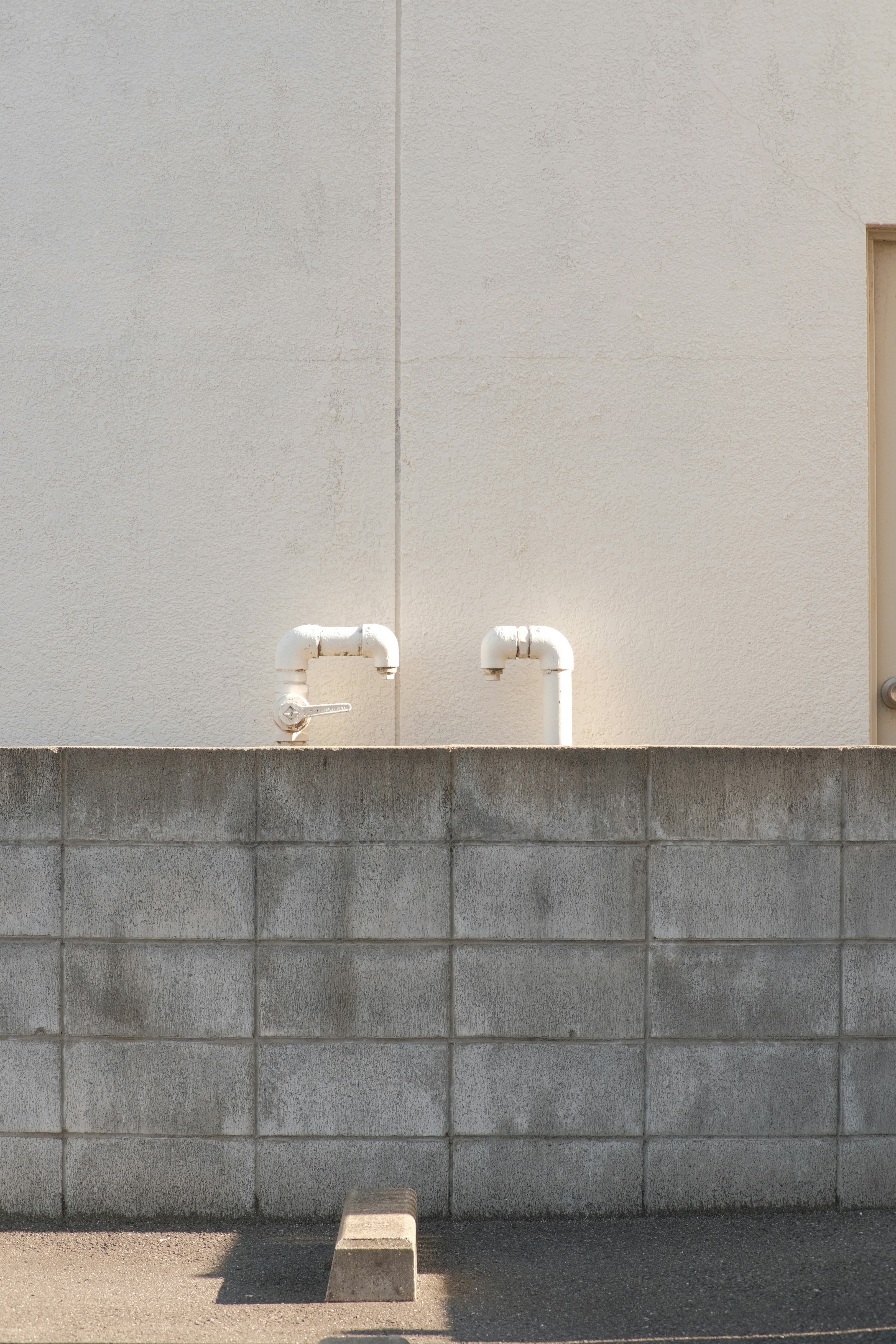 Thresholds of Quiet Industrialism: Pipes on a Plain Wall