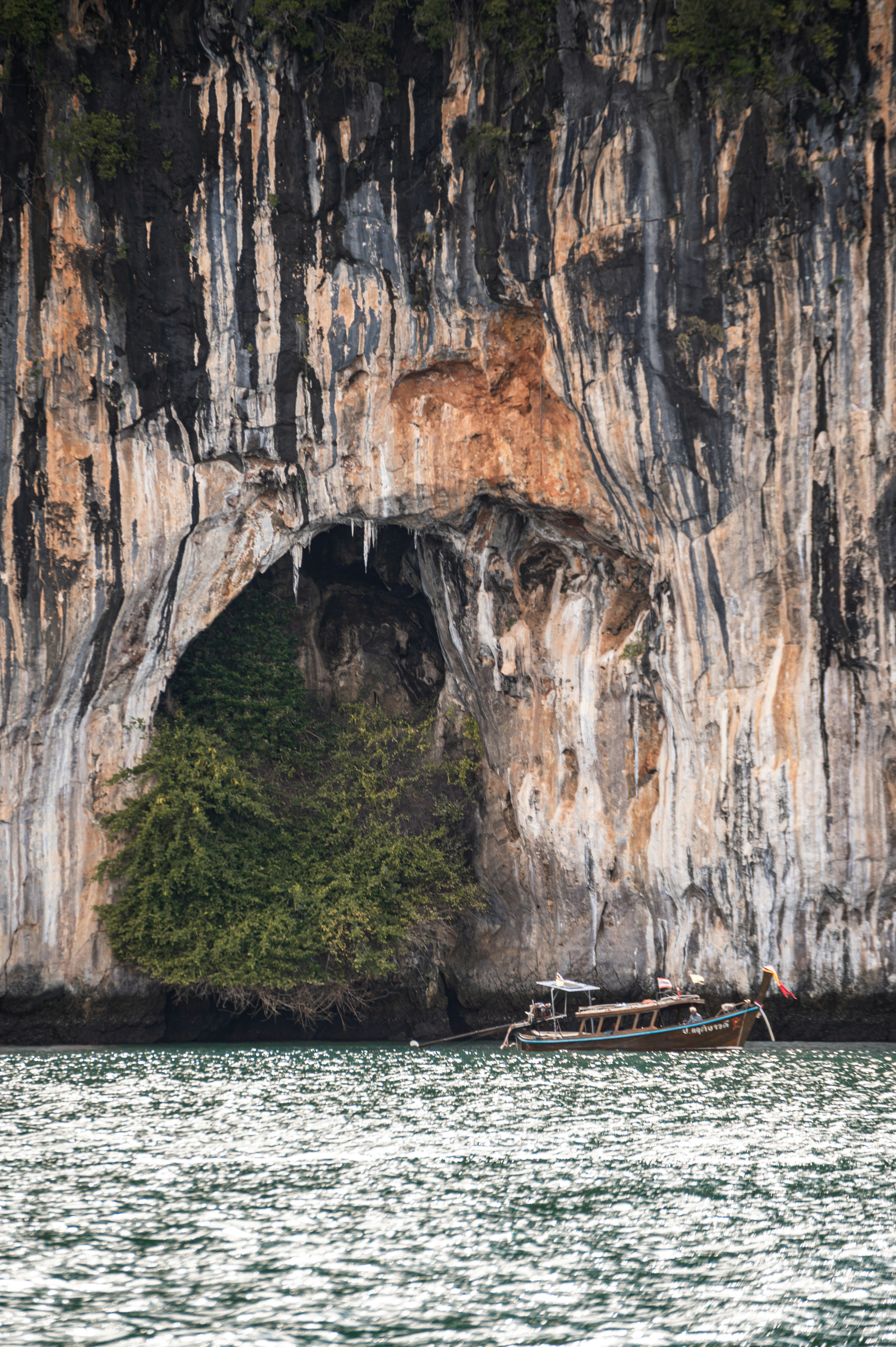 A boat in a body of water near a cliff photo – Free Cliff Image on Unsplash