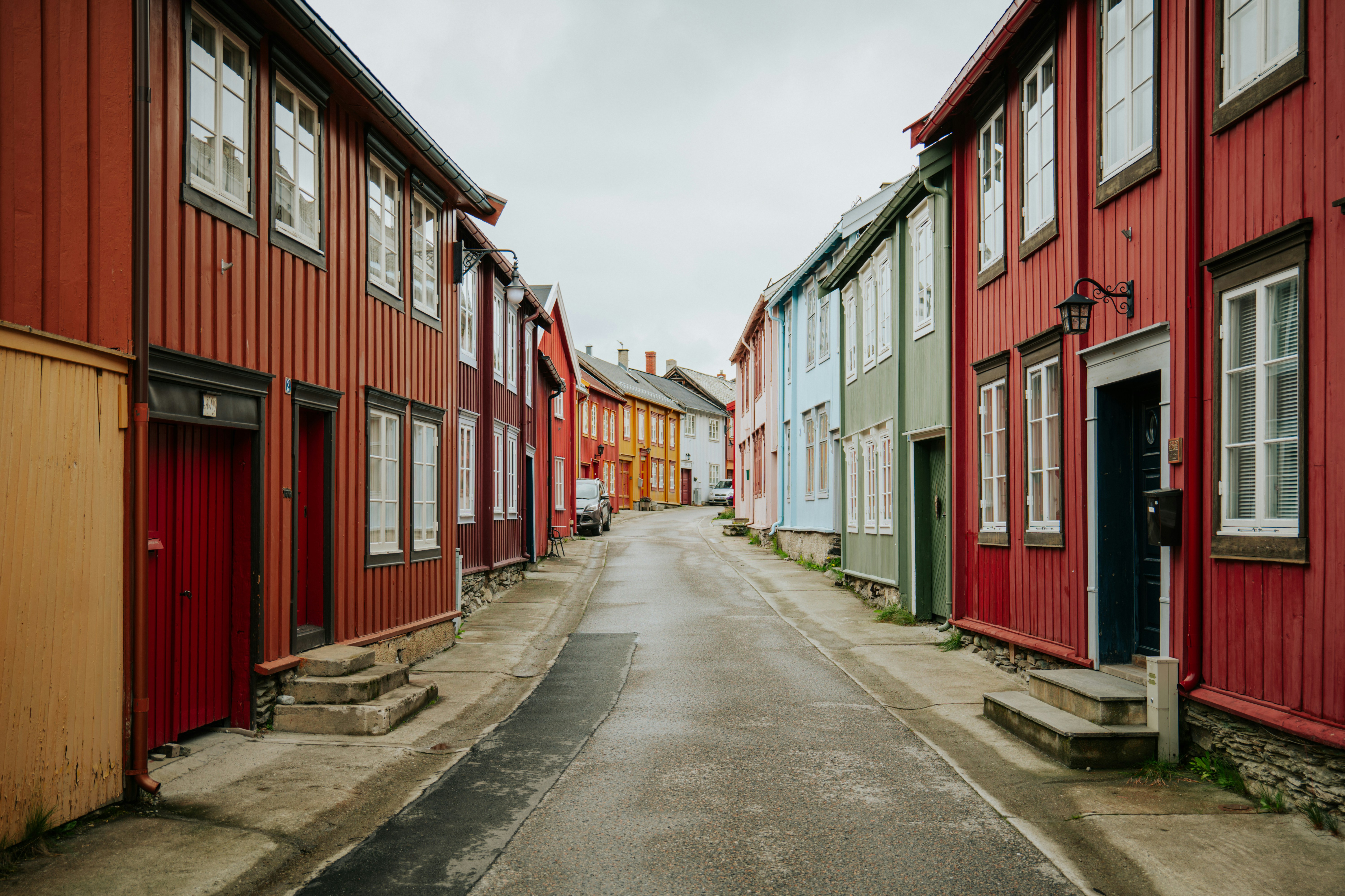 a narrow street lined with red and green buildings