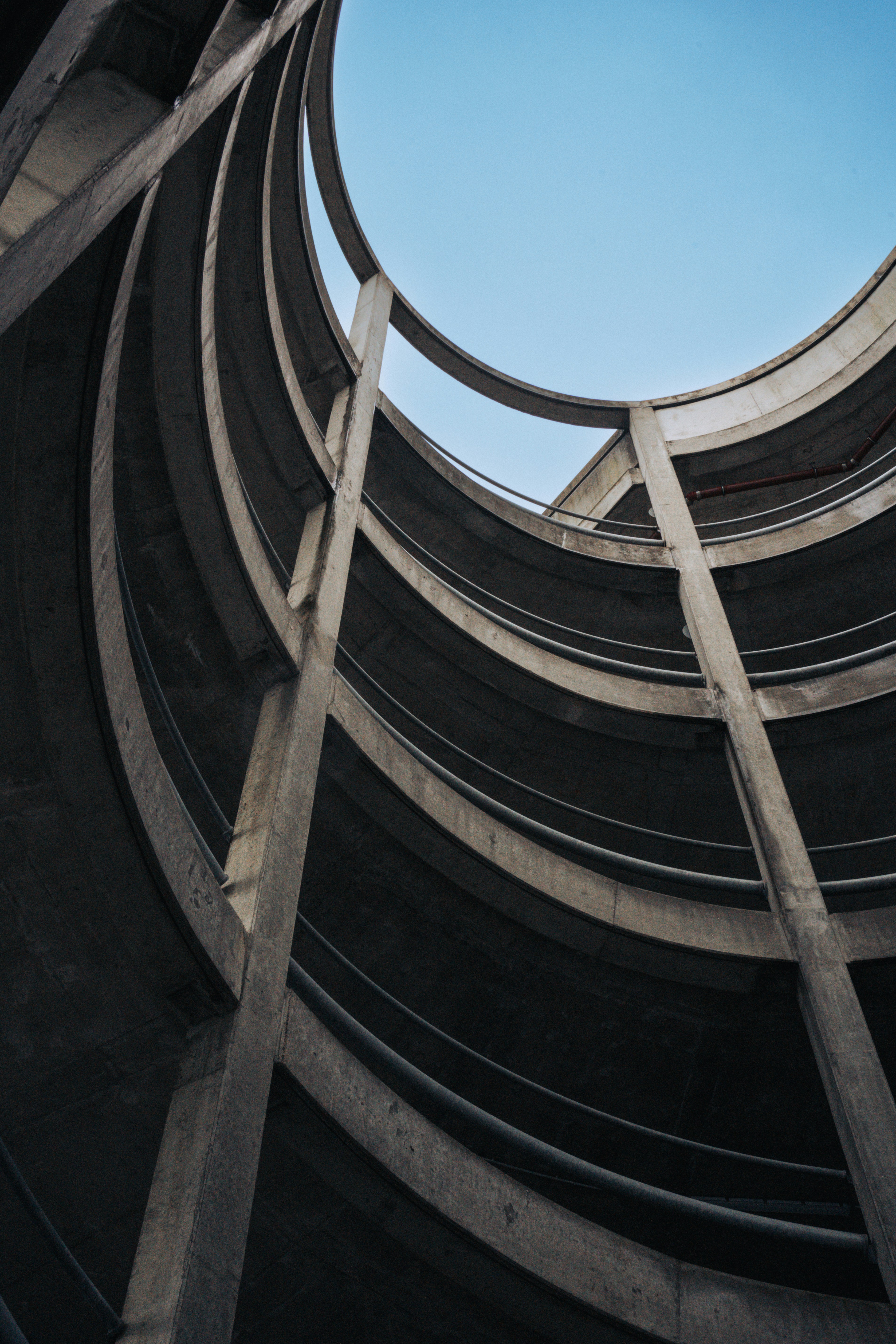 Looking up at a circular concrete structure with a blue sky in the ...