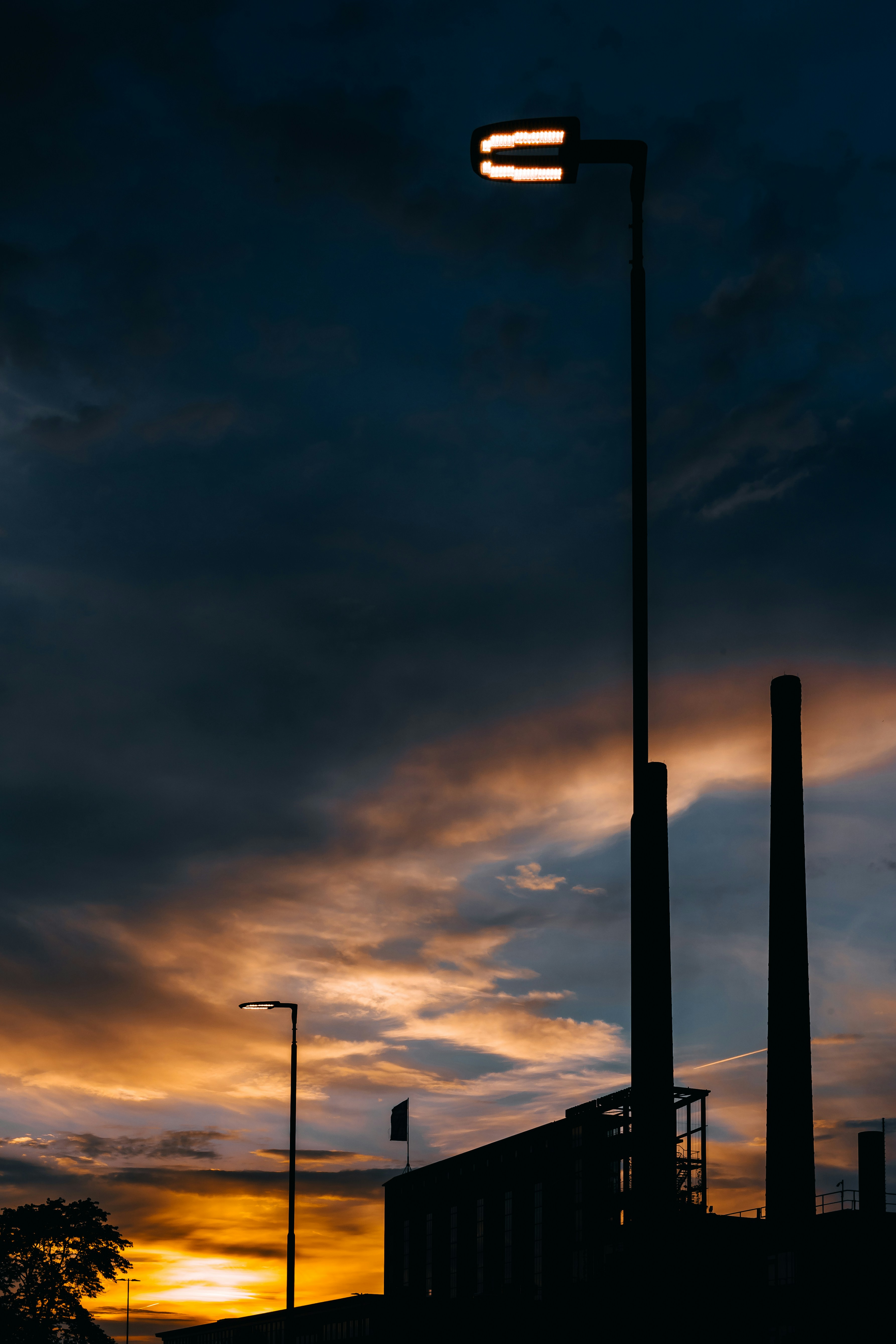 a street light sitting next to a building under a cloudy sky