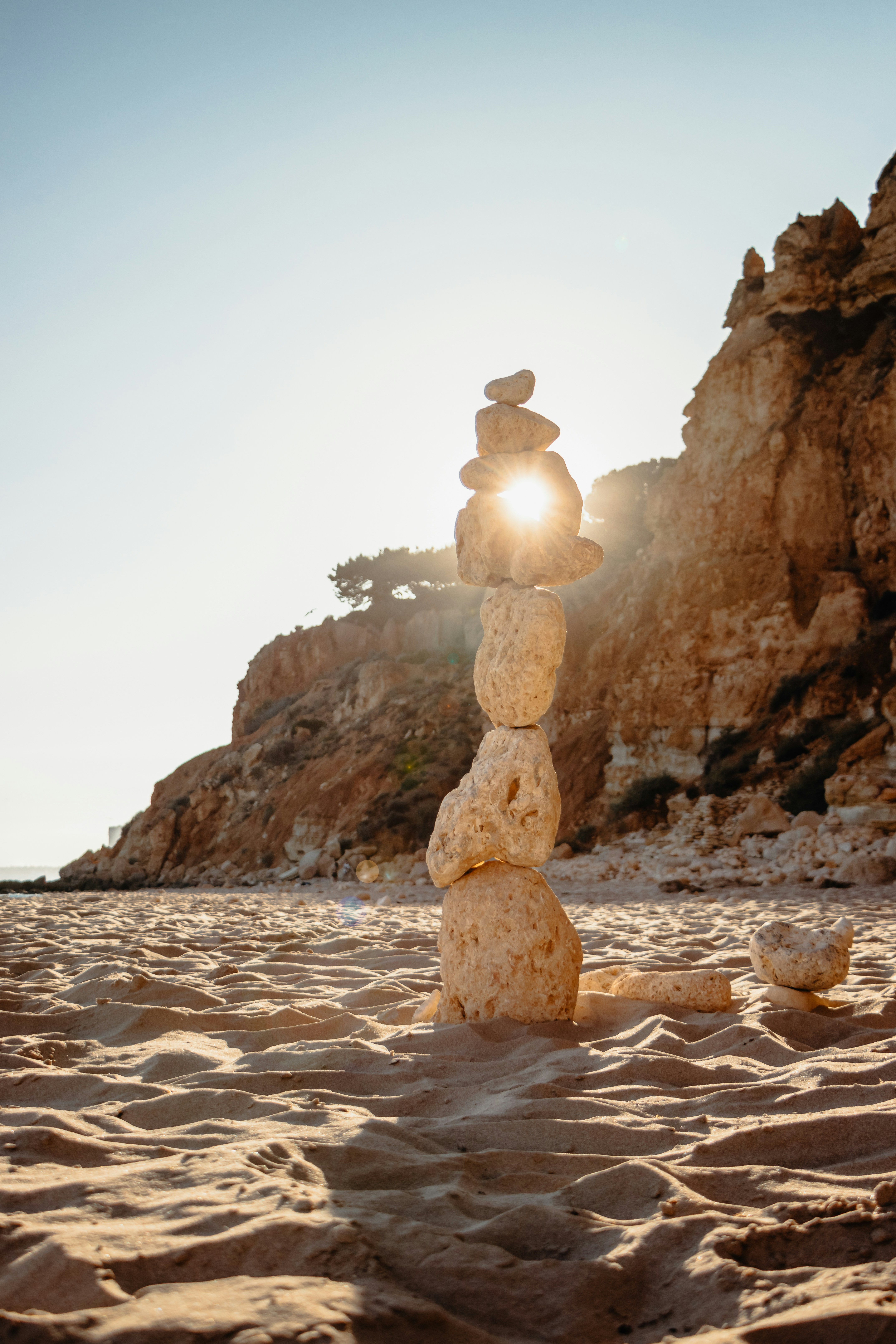 Sunlit Balance: A Tower of Stones on a Windswept Beach