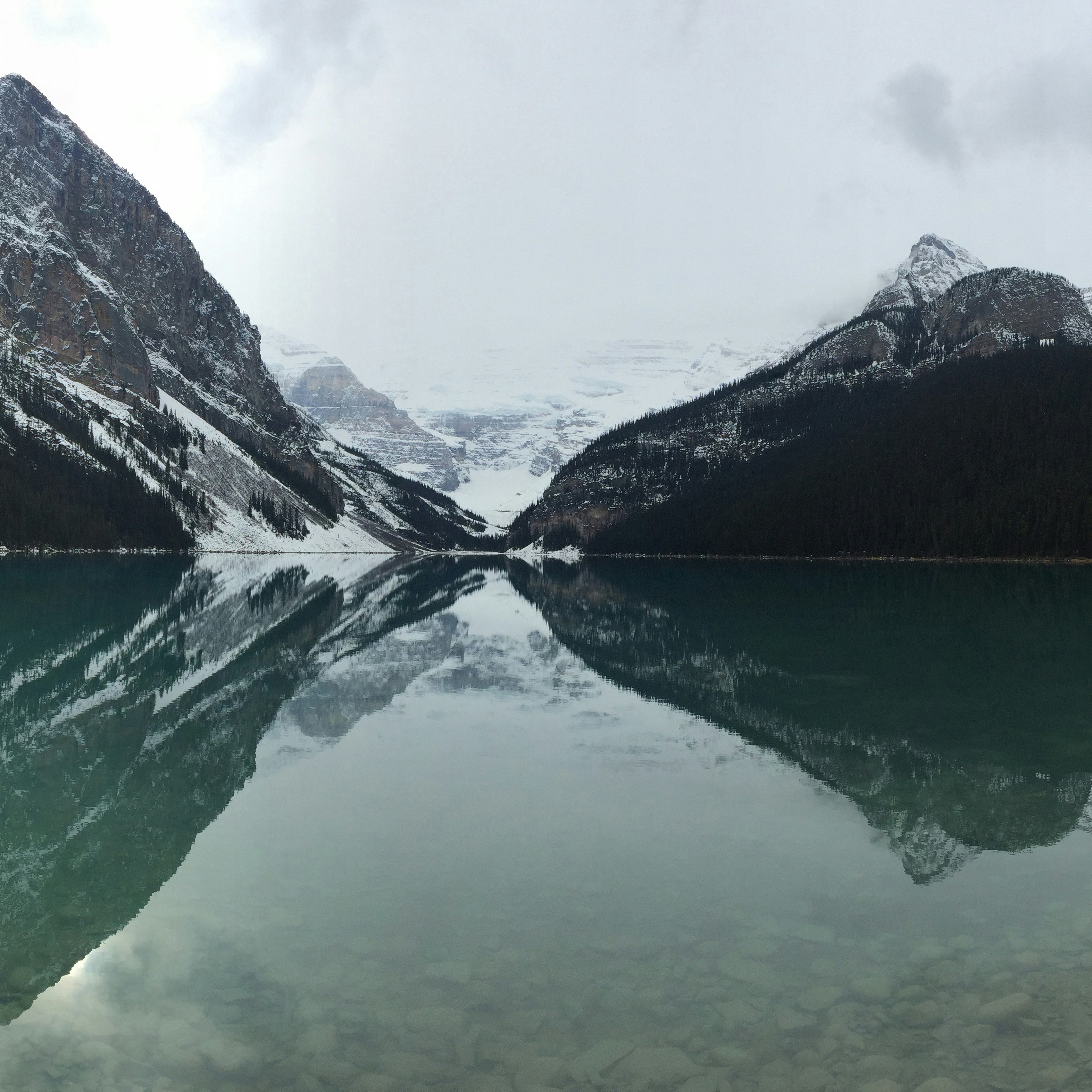 Glacial Mirror: Snowy Peaks Framed by a Tranquil Alpine Lake