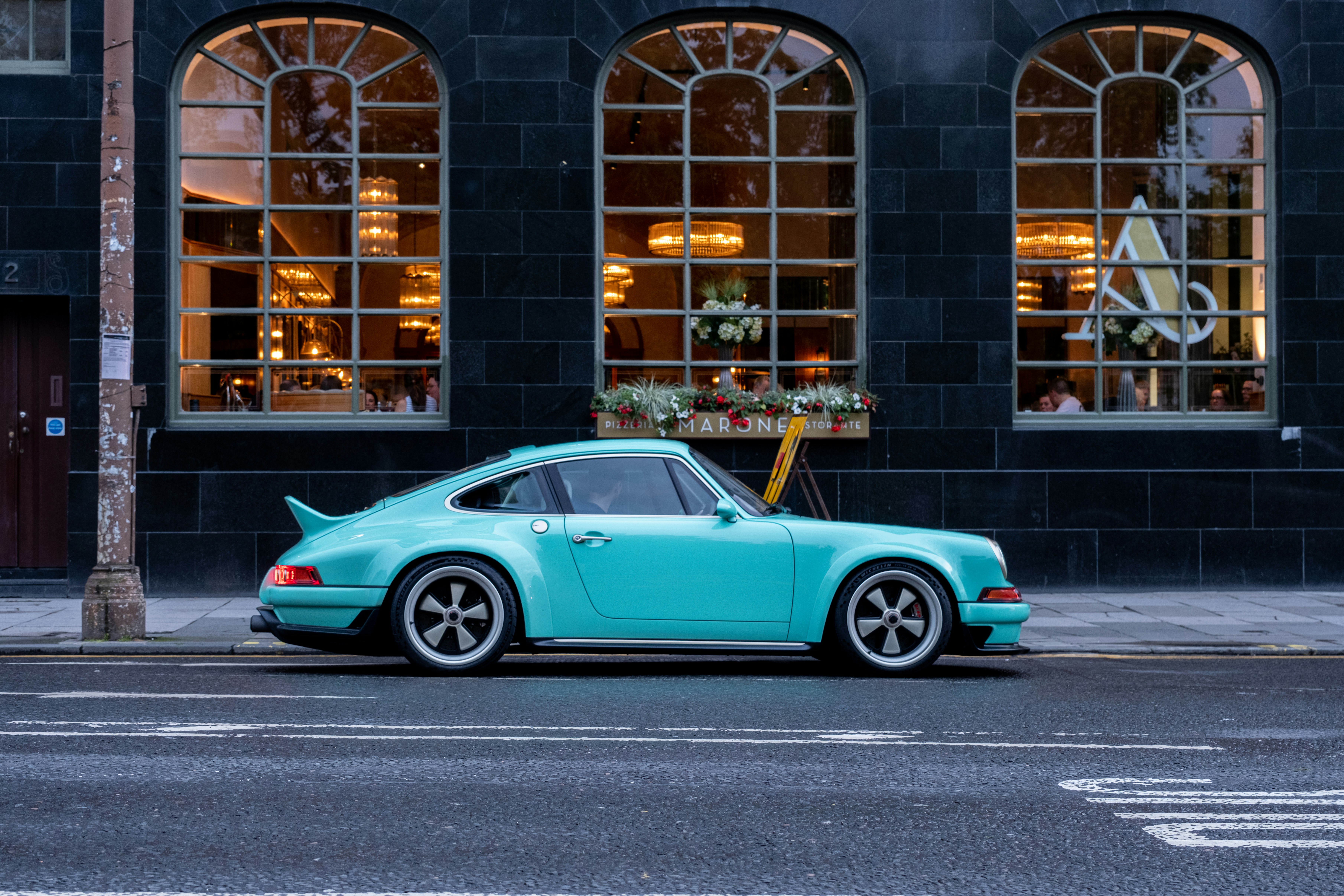 Turquoise Porsche on a Quiet City Street at Dusk