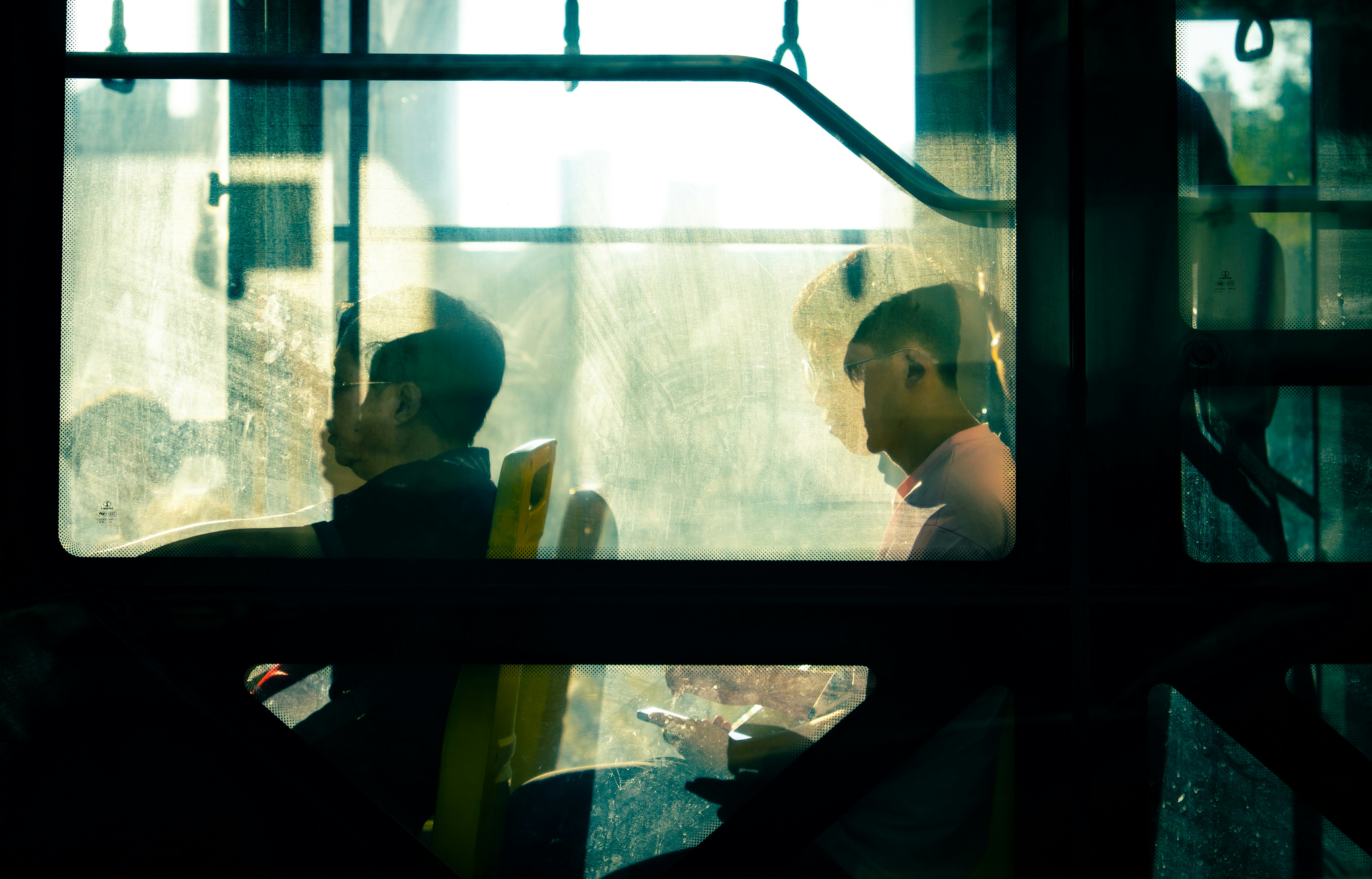 Two people sitting on a bus looking out the window photo – Free Person ...