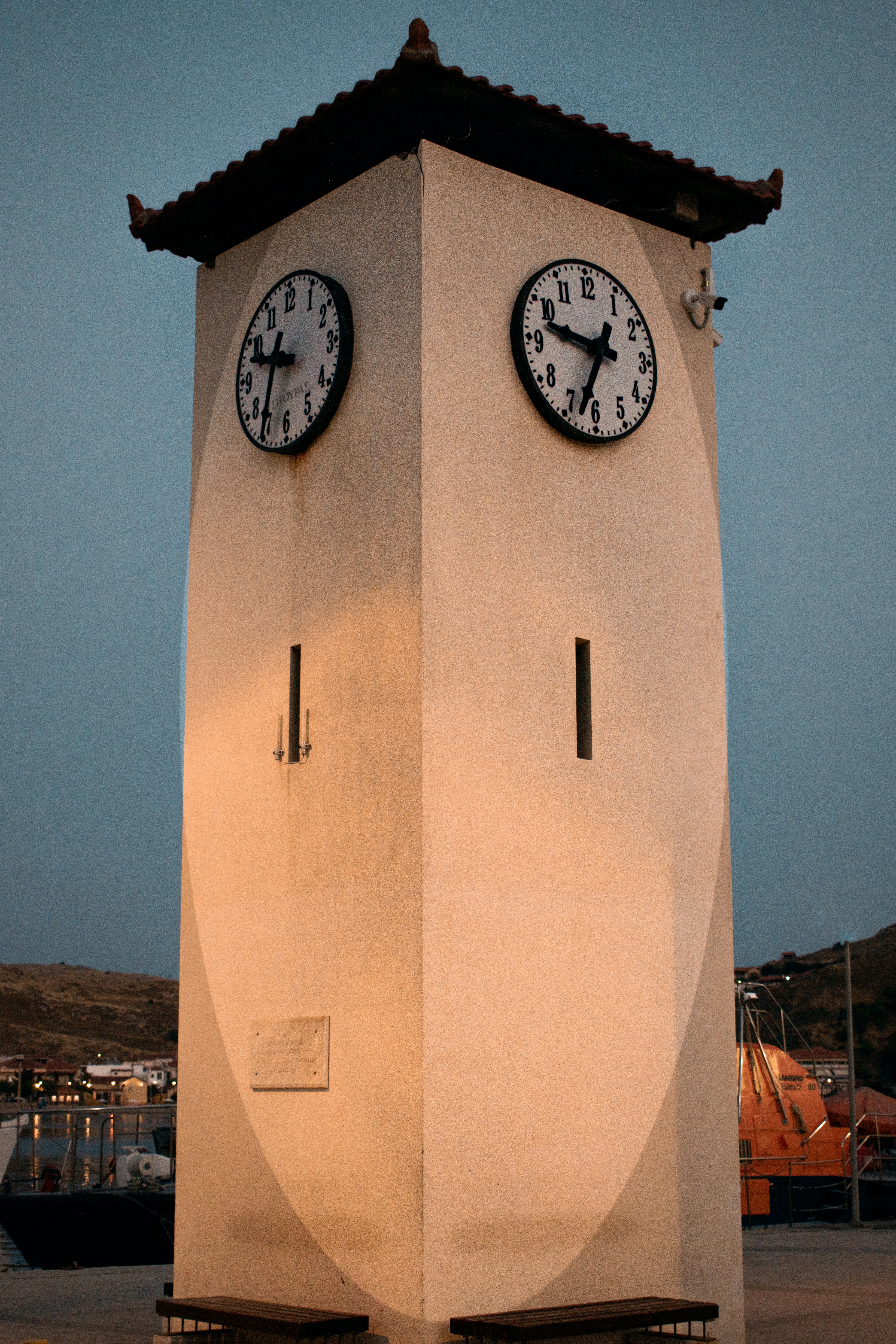 Dusk Clocktower Over the Harbor: Twin Dials in Warm Light