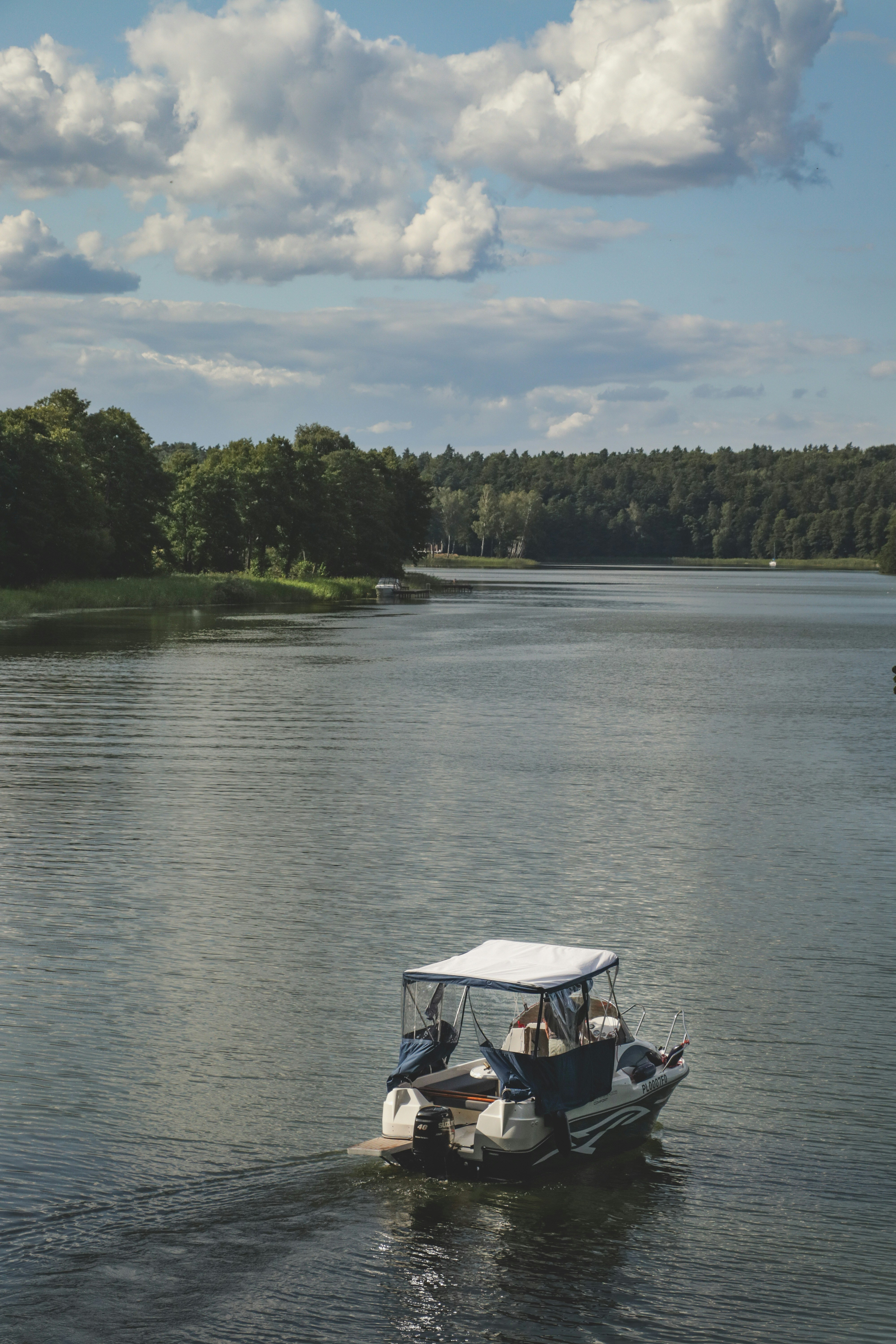 Riverbound Drift: A Quiet Tour Boat on a Tree-Lined Bend