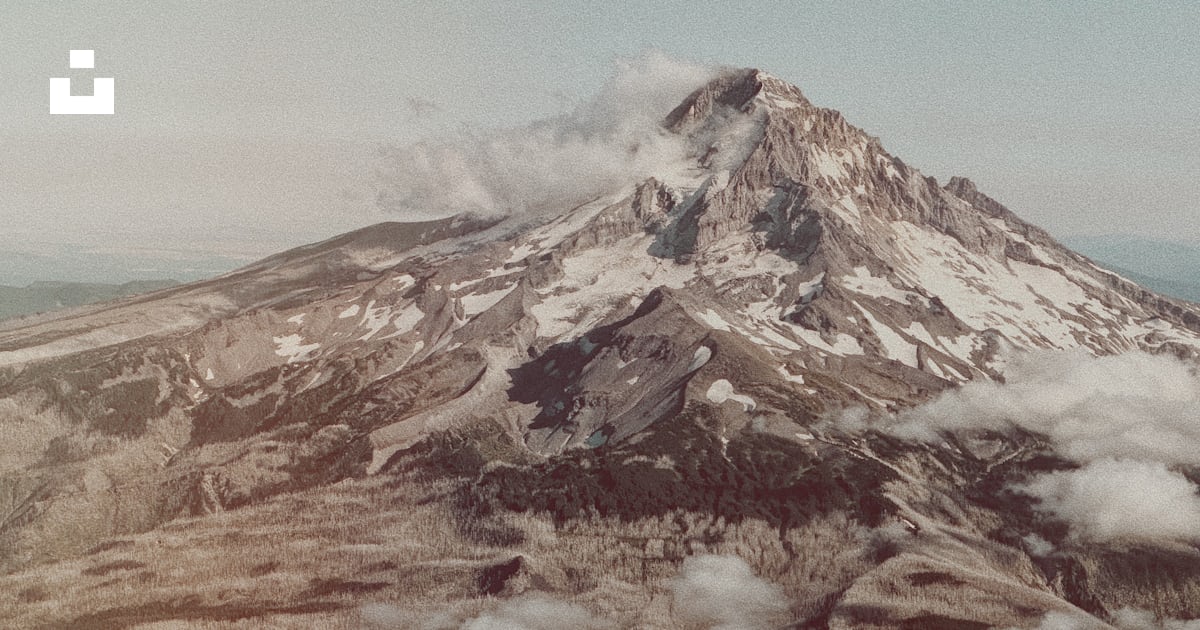 Une Montagne Couverte De Neige Et De Nuages Sous Un Ciel Bleu Photo