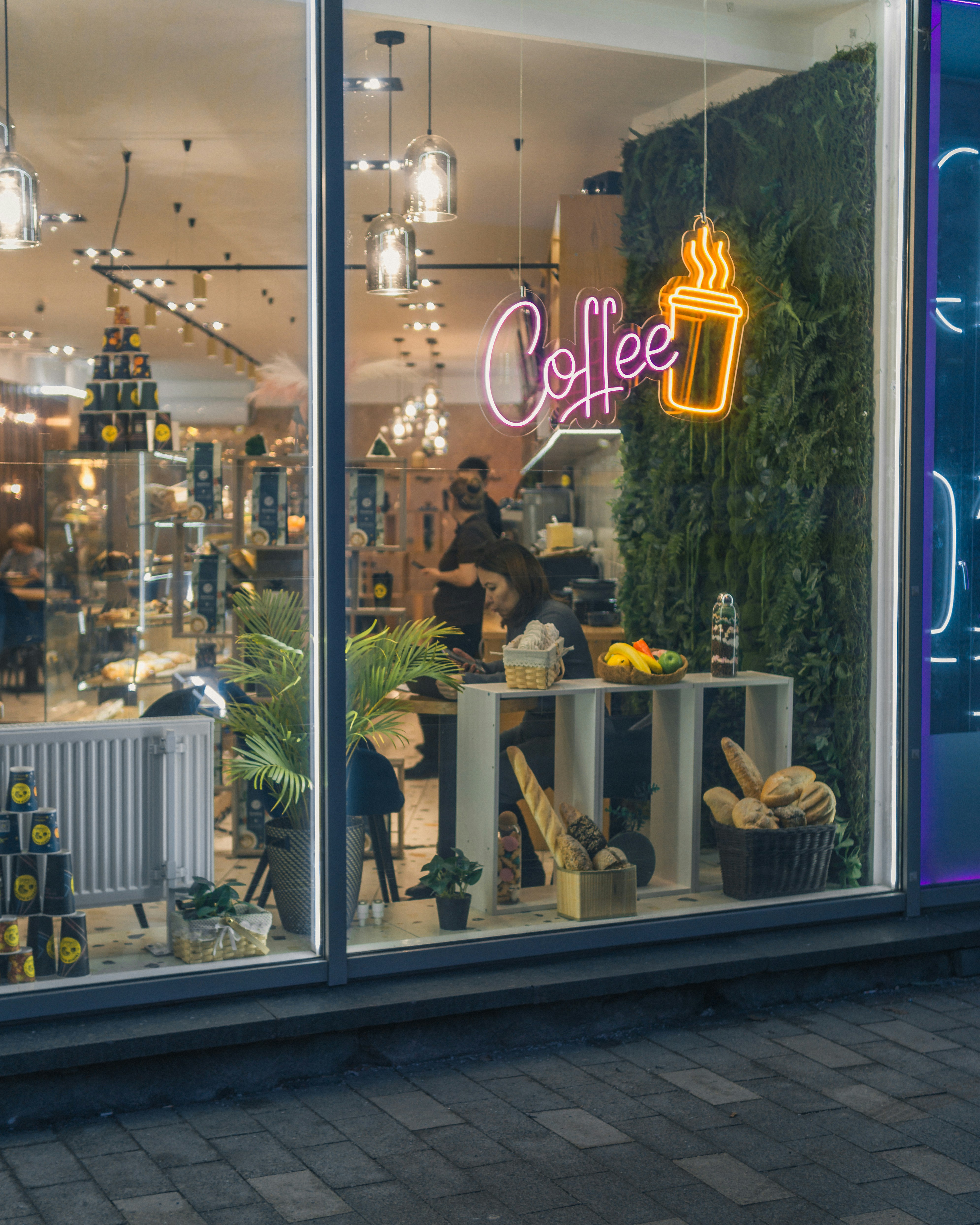 Neon Coffee Sign Framing a Lively Bakery Café Window