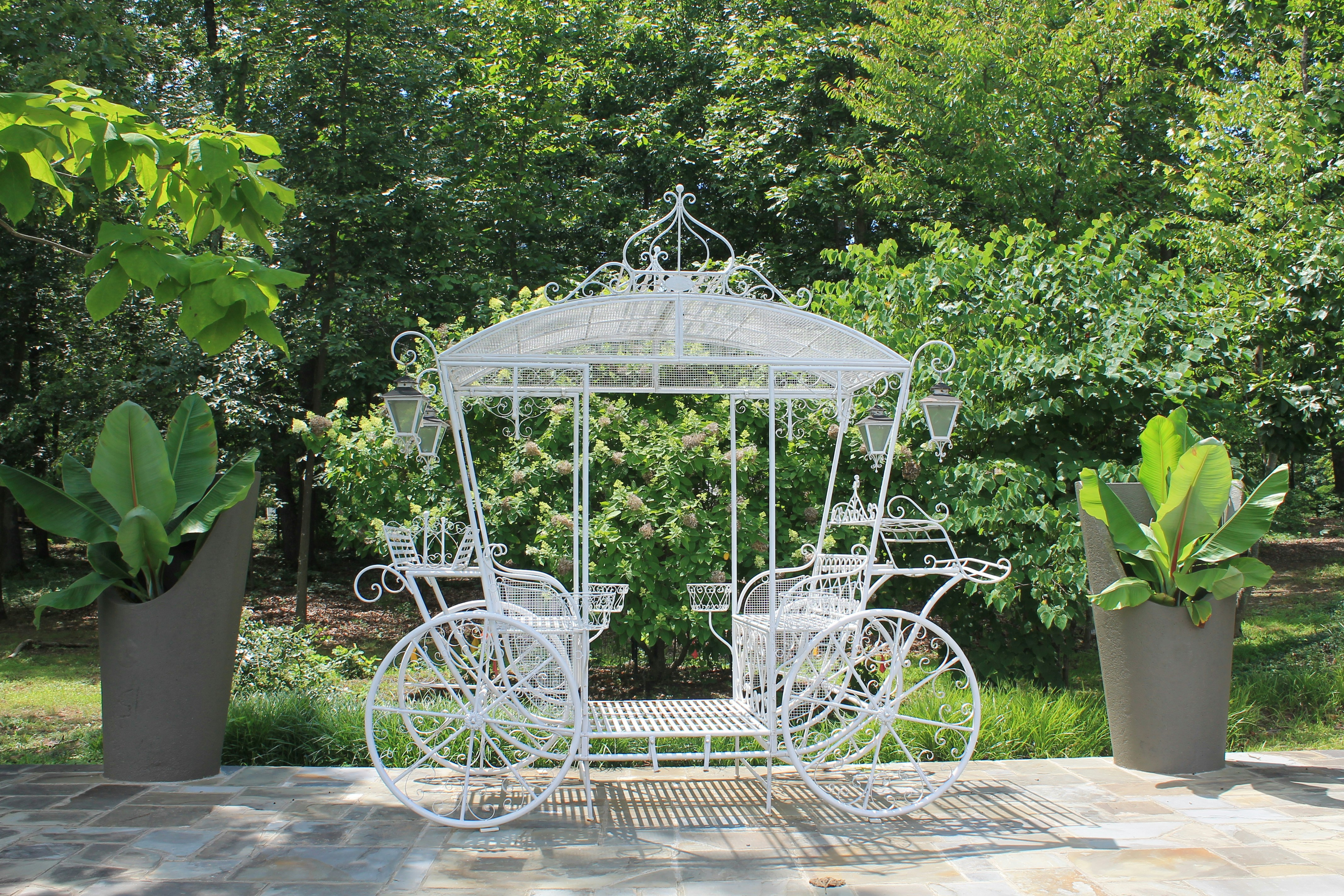 A white carriage sitting on top of a stone patio photo – Free Plant ...