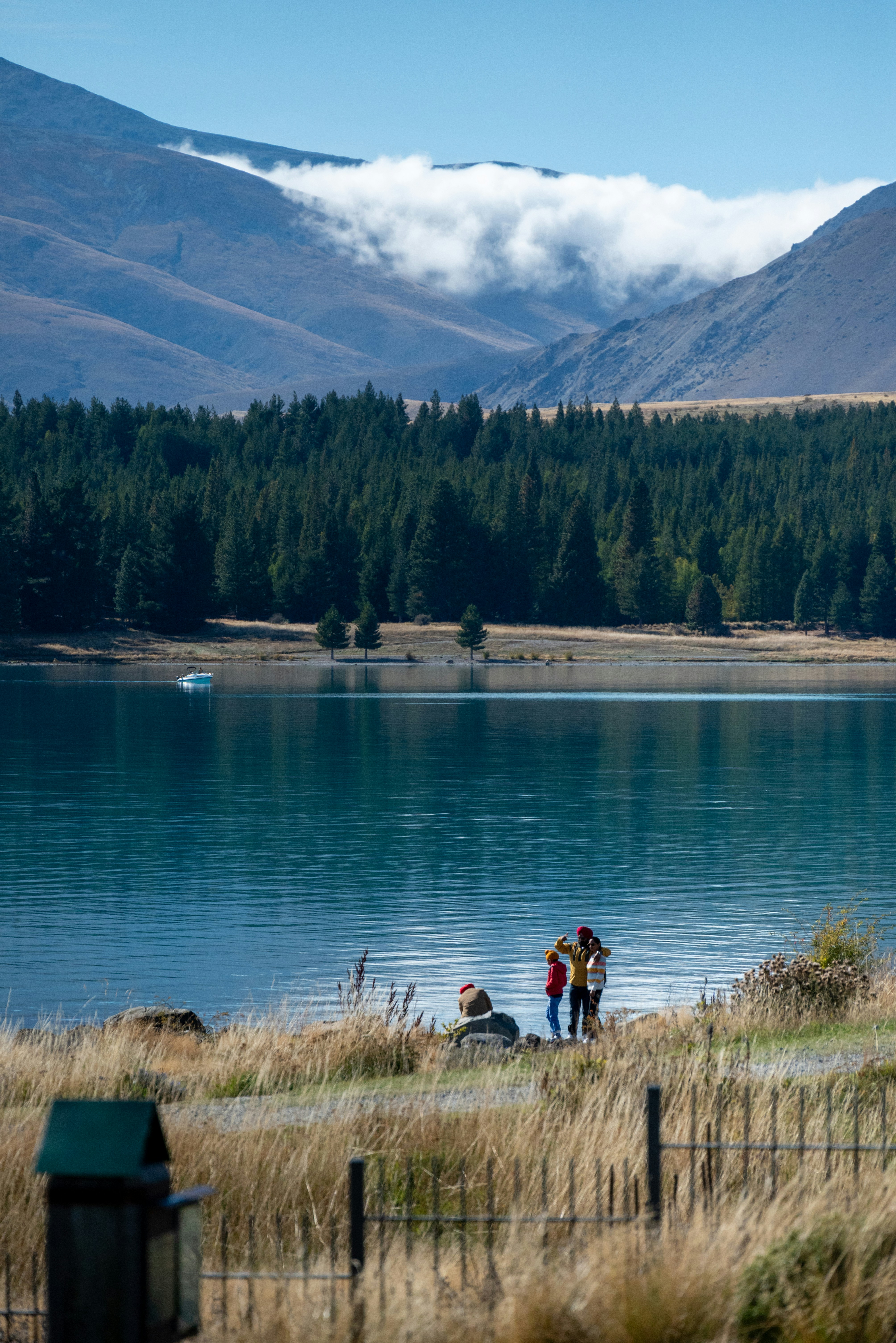 Quiet Lakeside Portrait: People by the Water under Mountain Crest