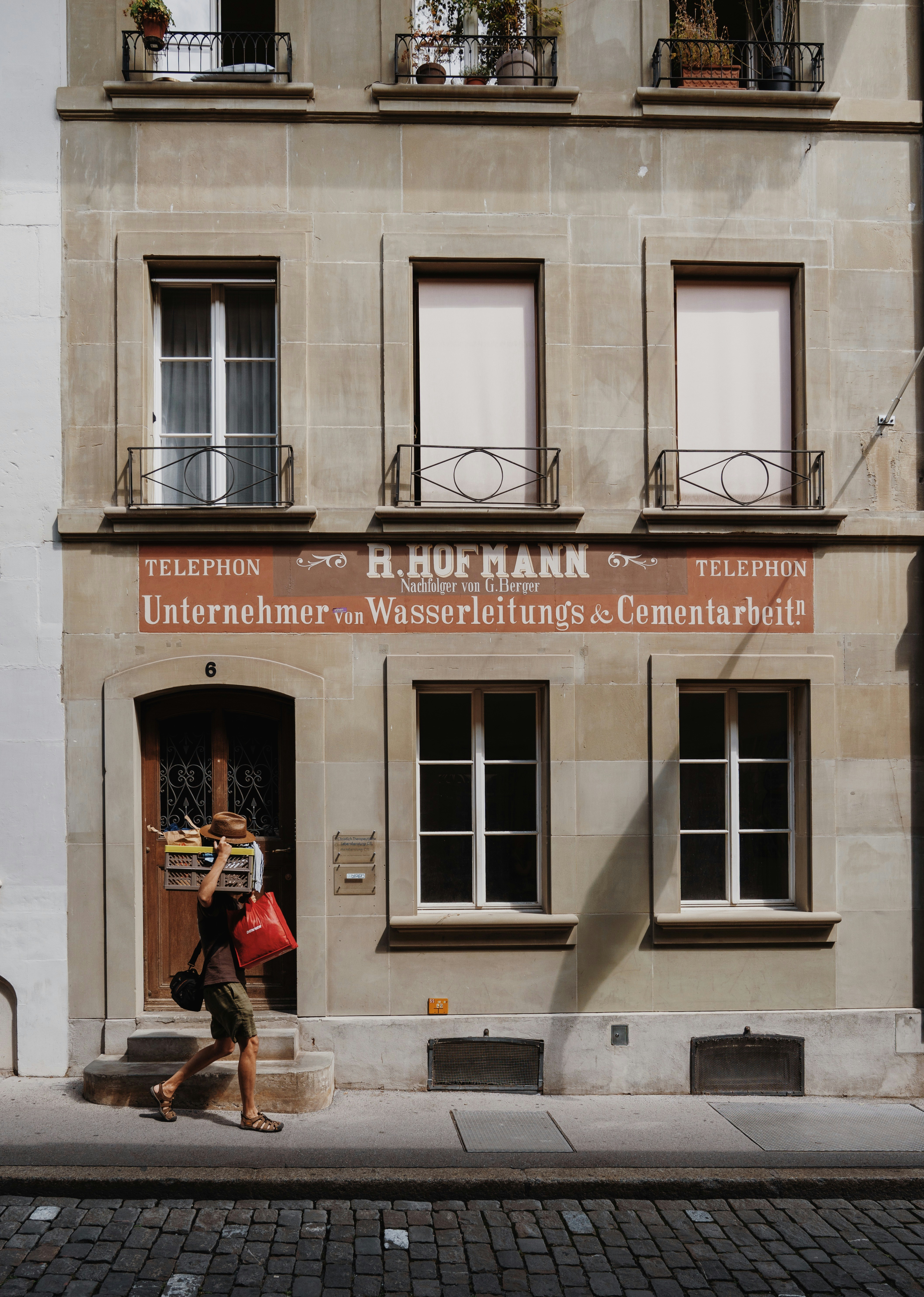 A person walking past a tall building with windows photo – Free Bern ...