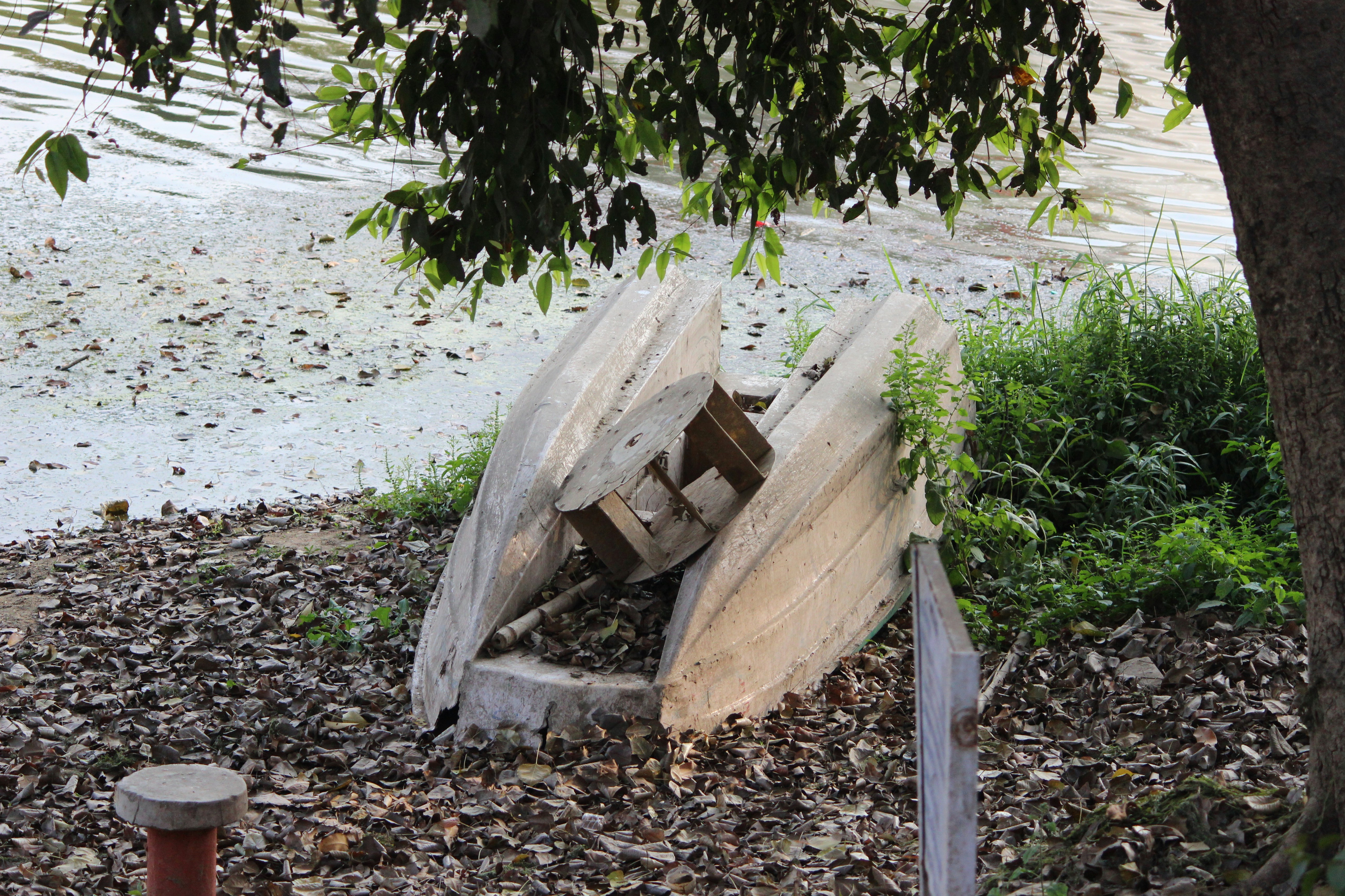 A wooden boat sitting on top of a pile of rubble photo – Free India ...