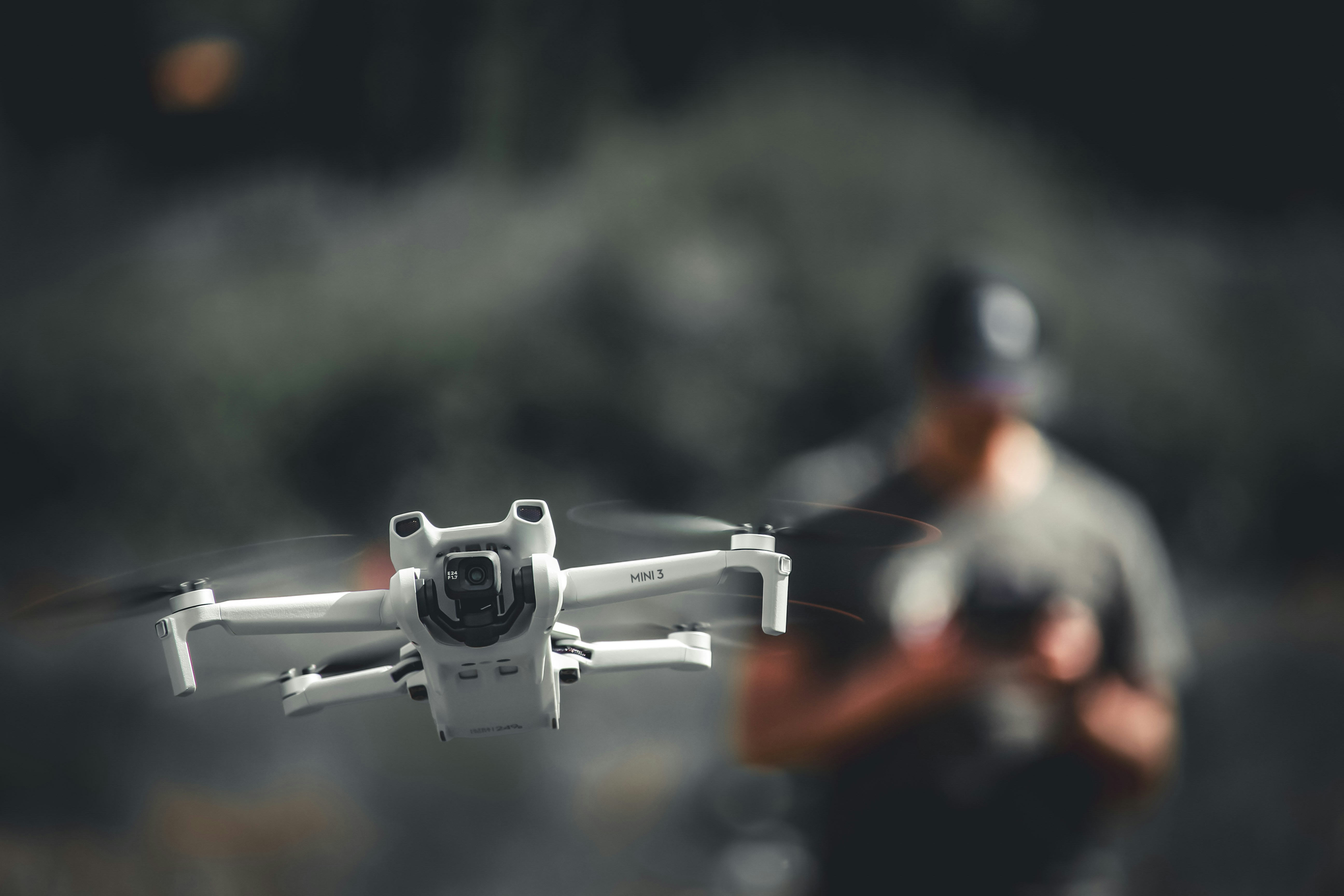 A man holding a white and black remote control flying a white and black ...