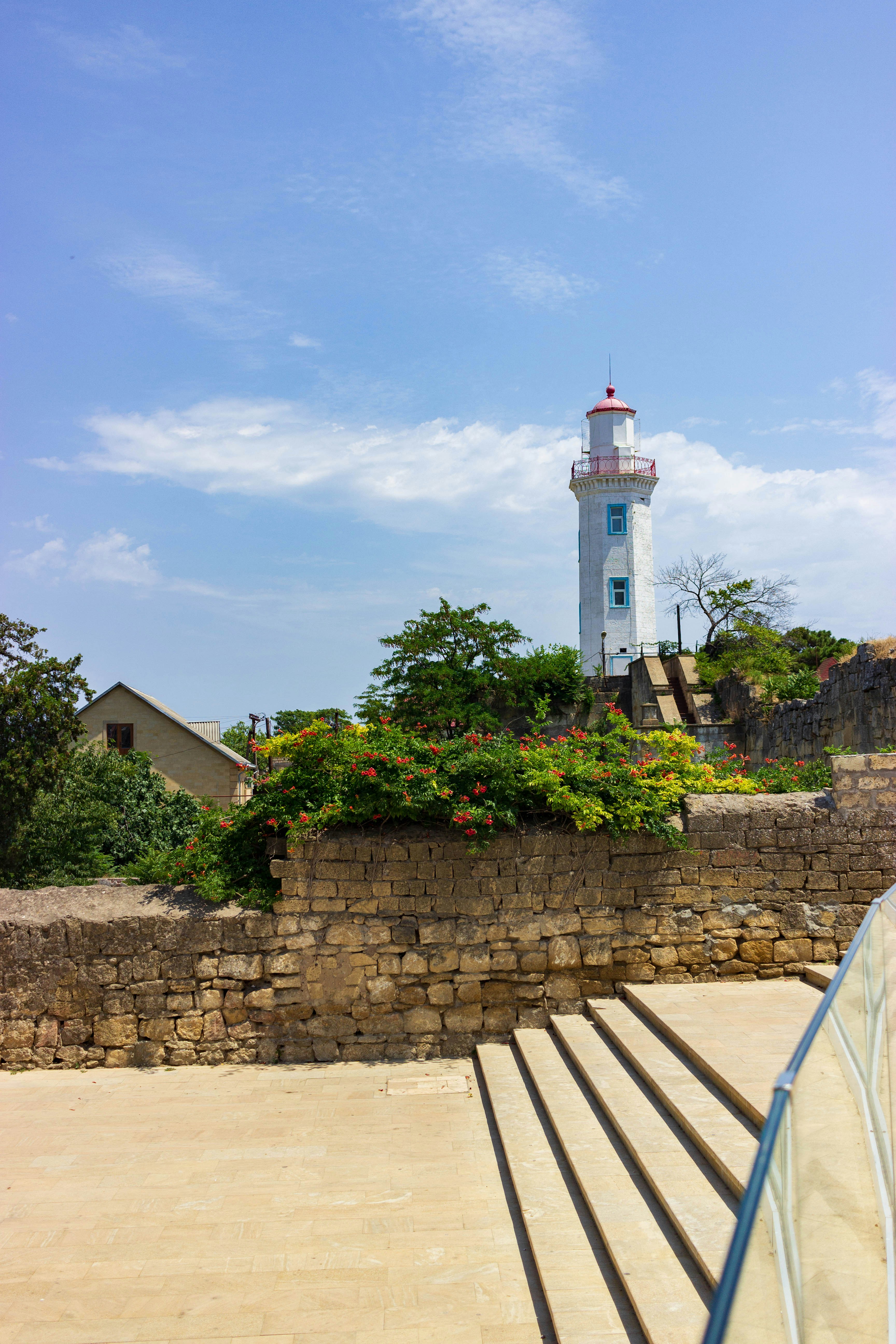 Beacon Above the Stone Terrace: A Coastal Lighthouse under a Wide Sky