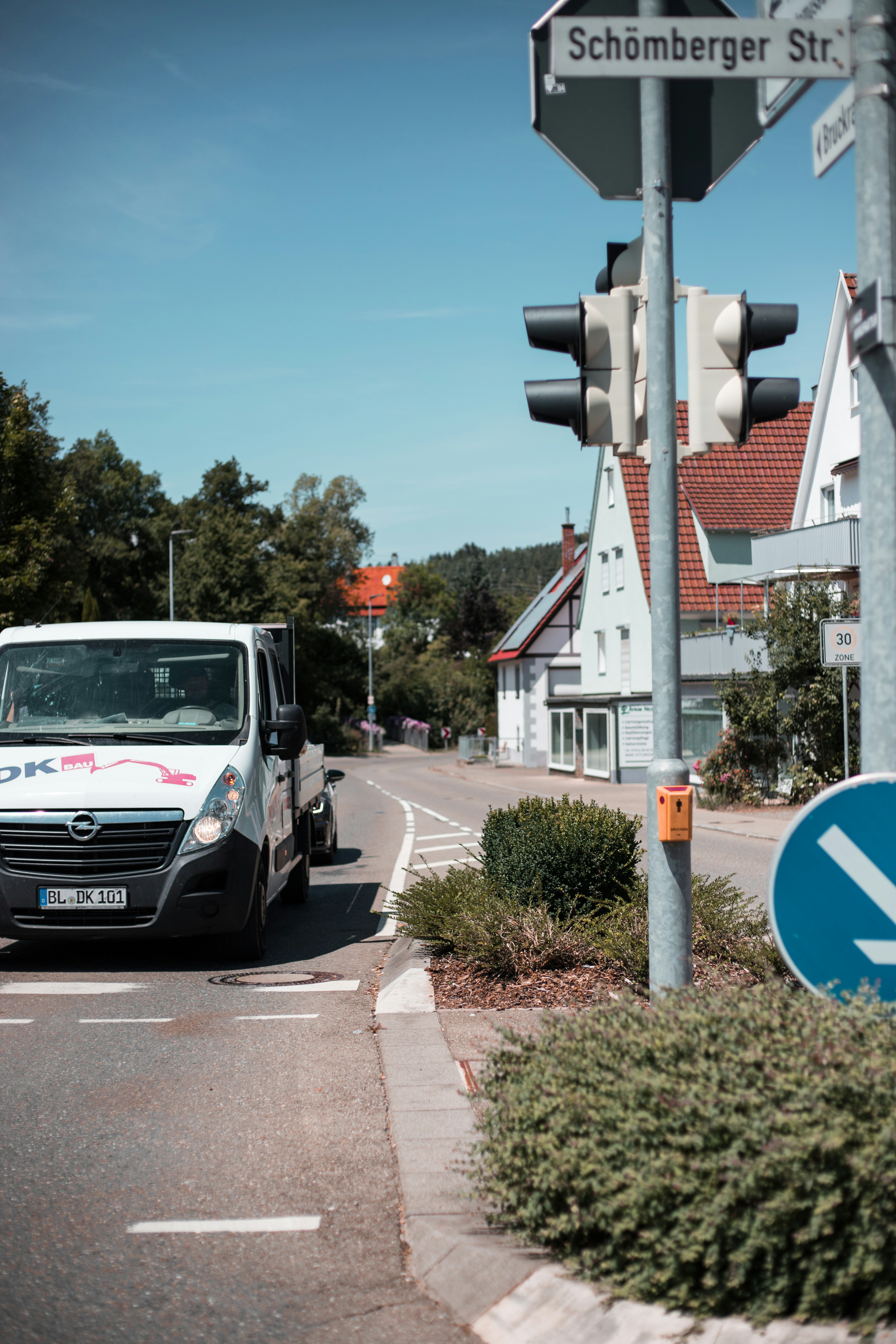 Lane of Street Signs and a White Delivery Van at a Quiet German Town Intersection