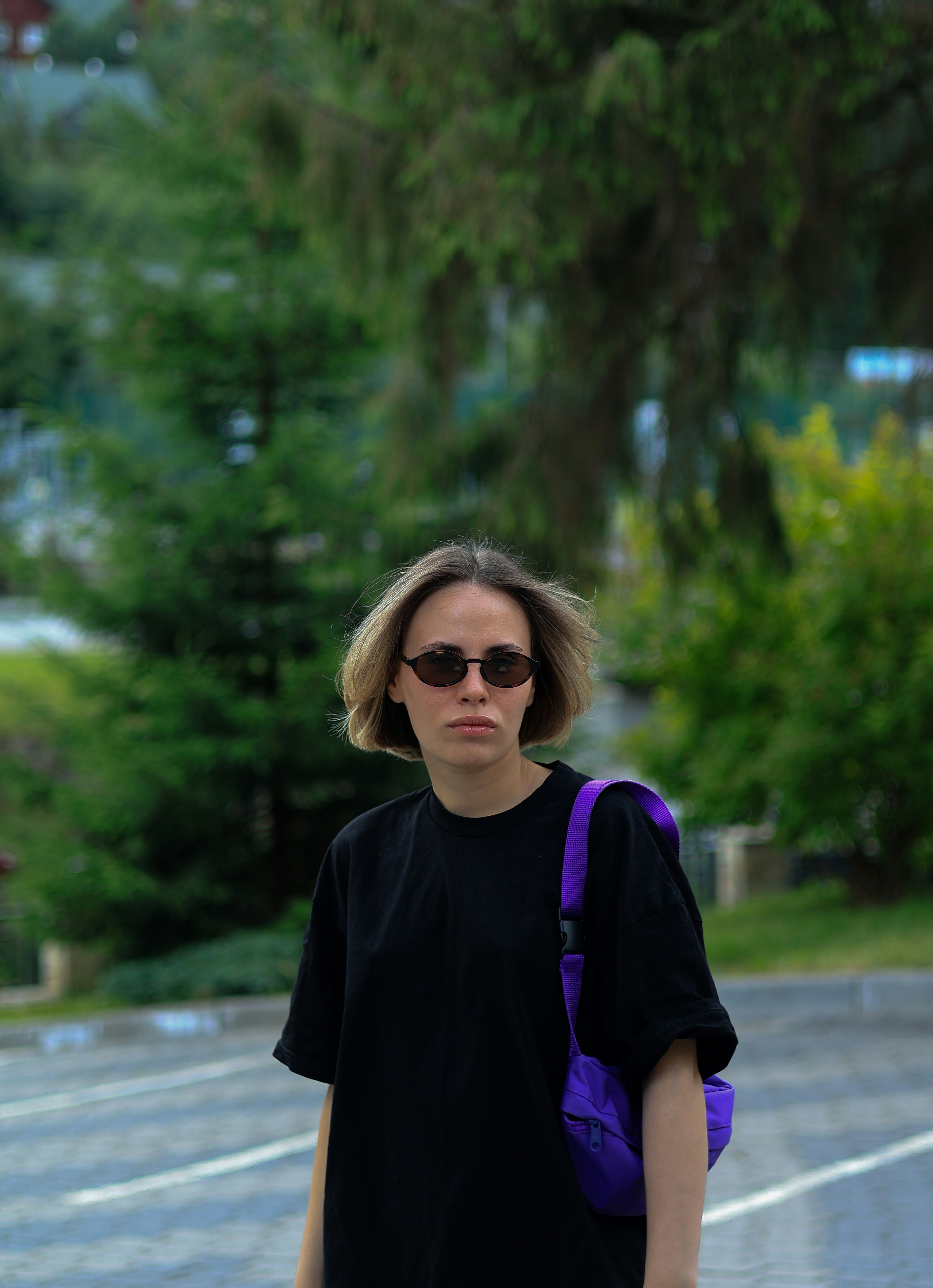 Quiet Portrait in Verdant Blur: A Woman in Black and Violet