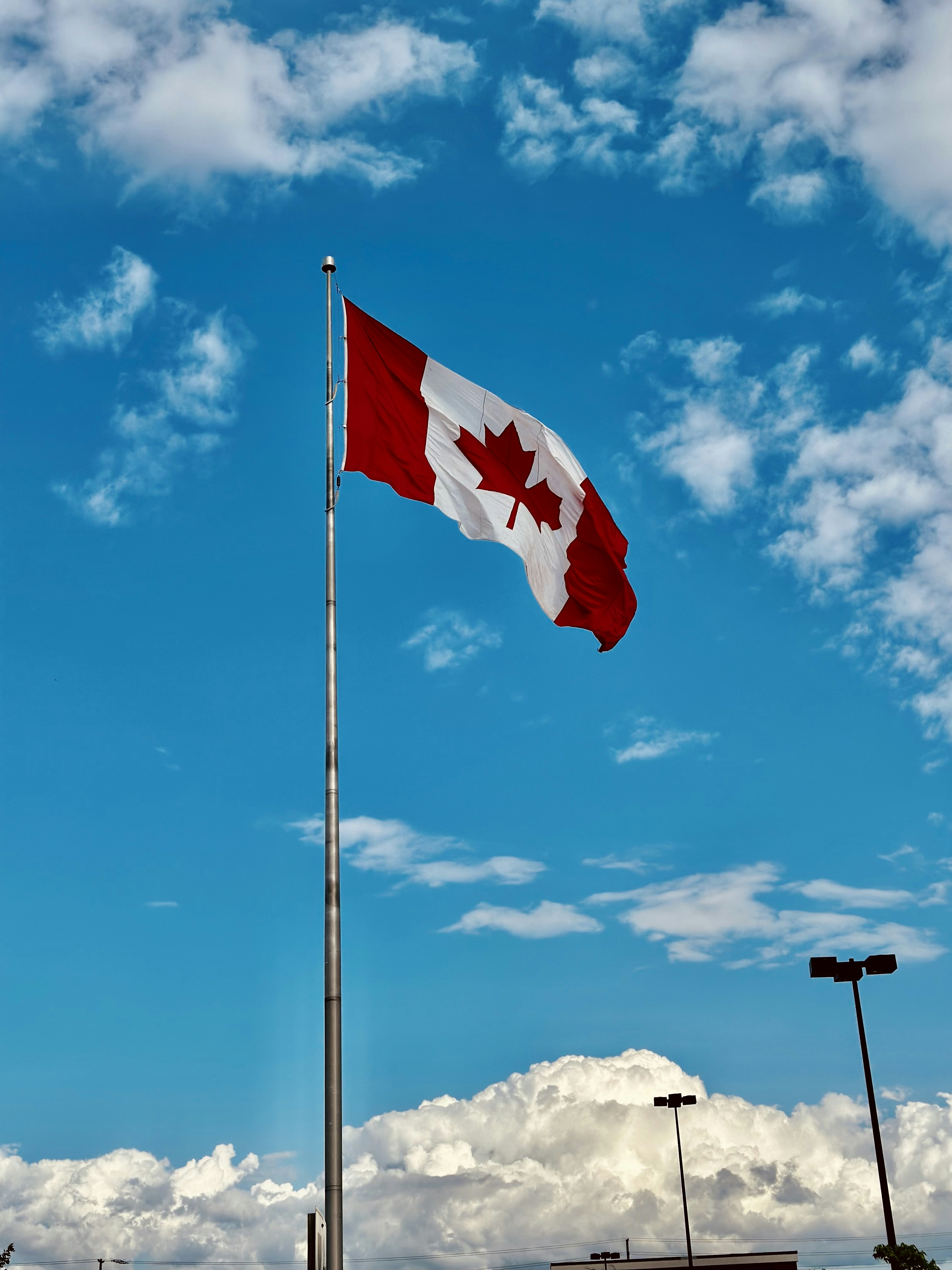 A canadian flag flying high in the sky photo – Free Wallpaper Image on ...
