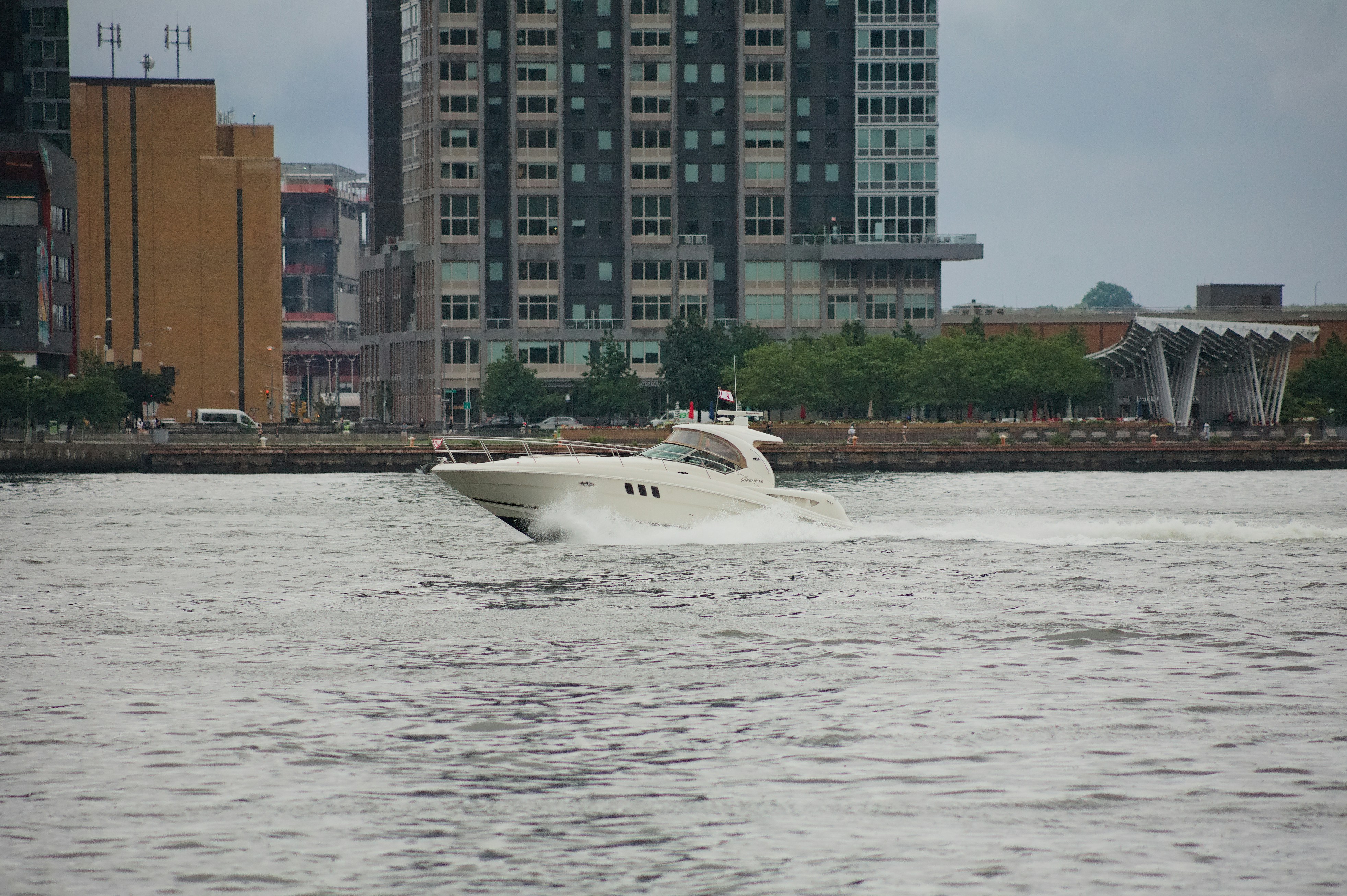 Urban Harbor Sleek: A Luxury Yacht Cuts Through City Wake