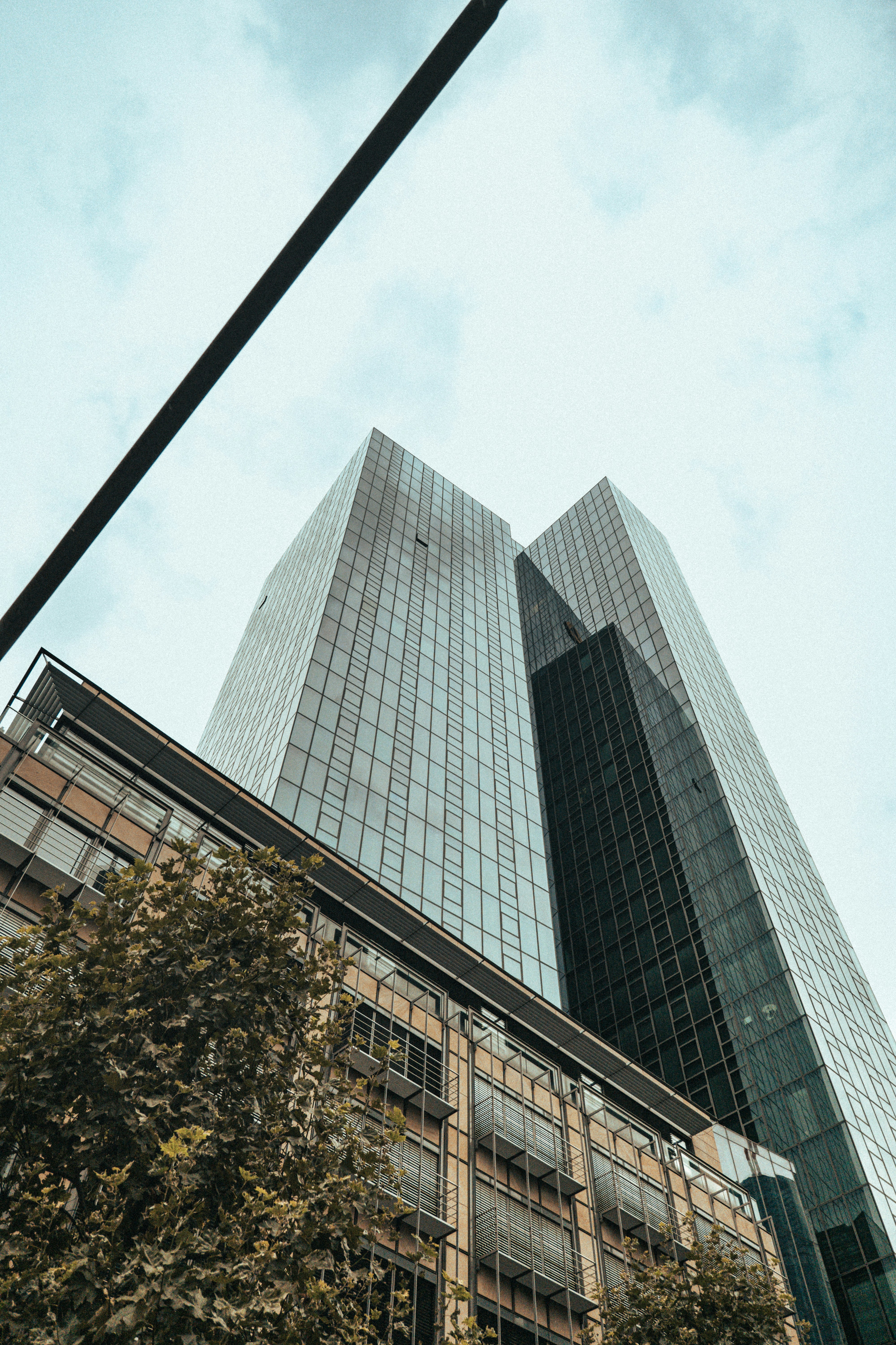 Diagonal Convergence: Twin Glass Towers Under a Pale Sky